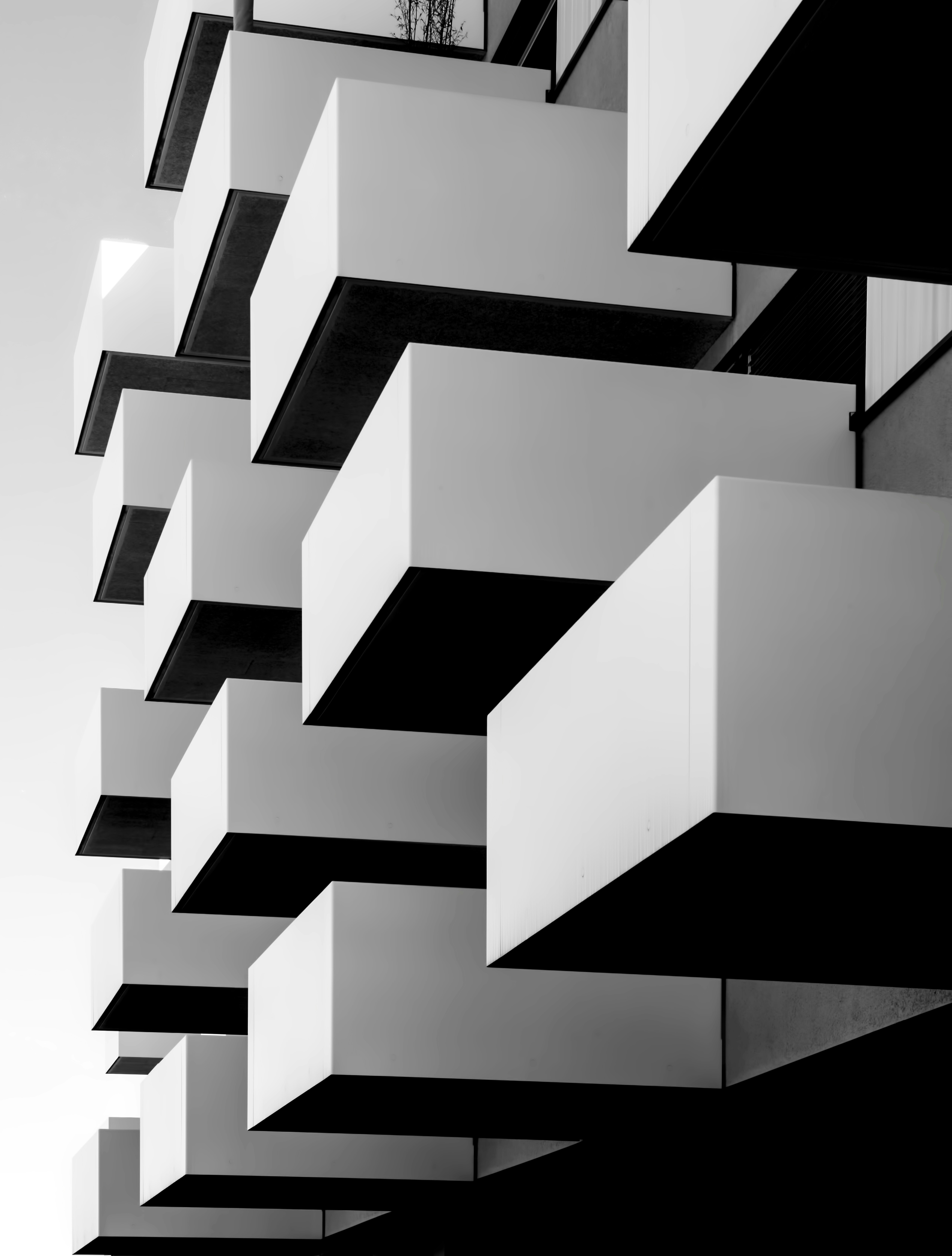 Abstract architectural composition featuring layered white balconies against a stark background. The interplay of shapes creates a striking visual rhythm.