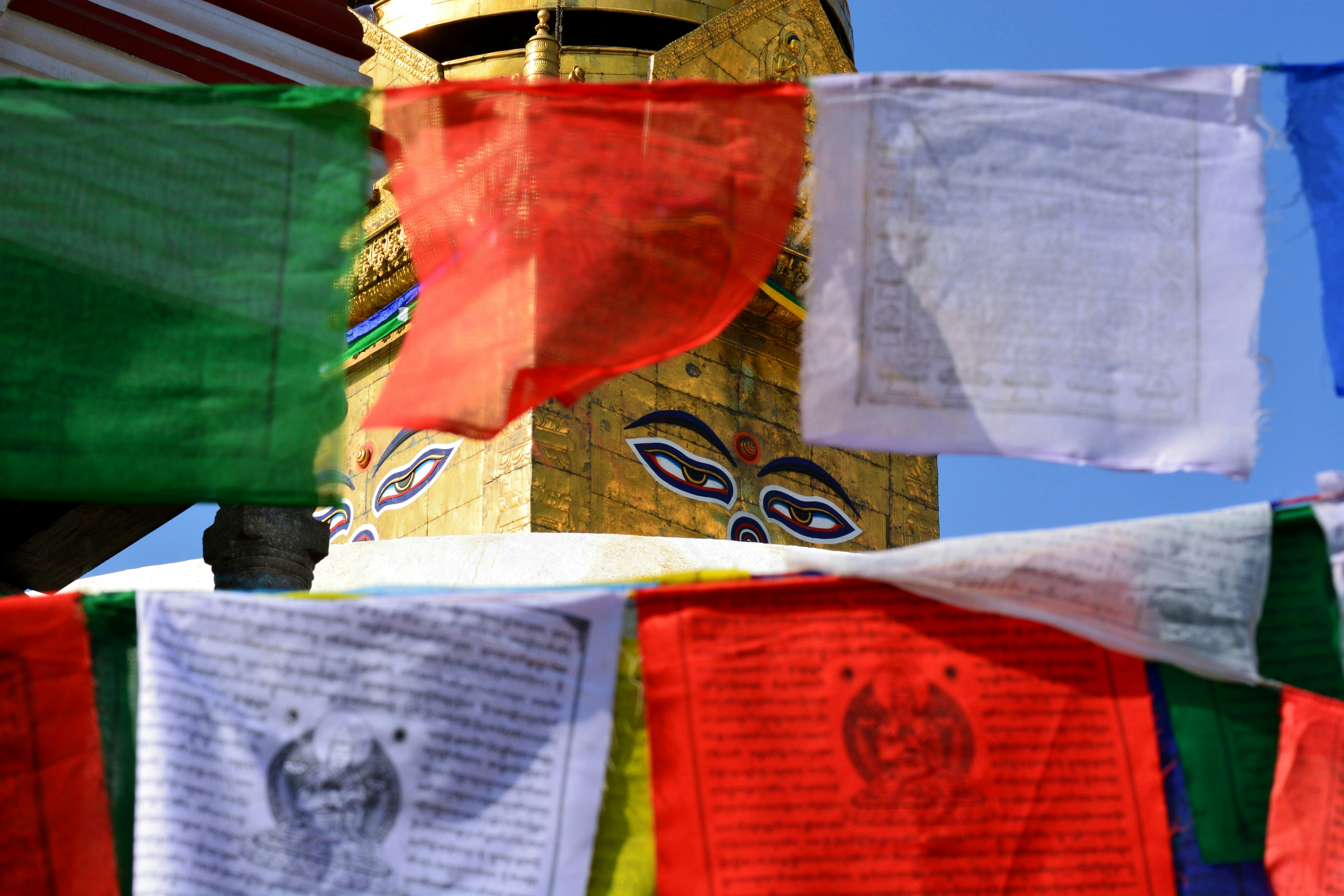 Crimson Flag Framing a Golden Spire: Prayer Flags Embrace a Sacred Stupa