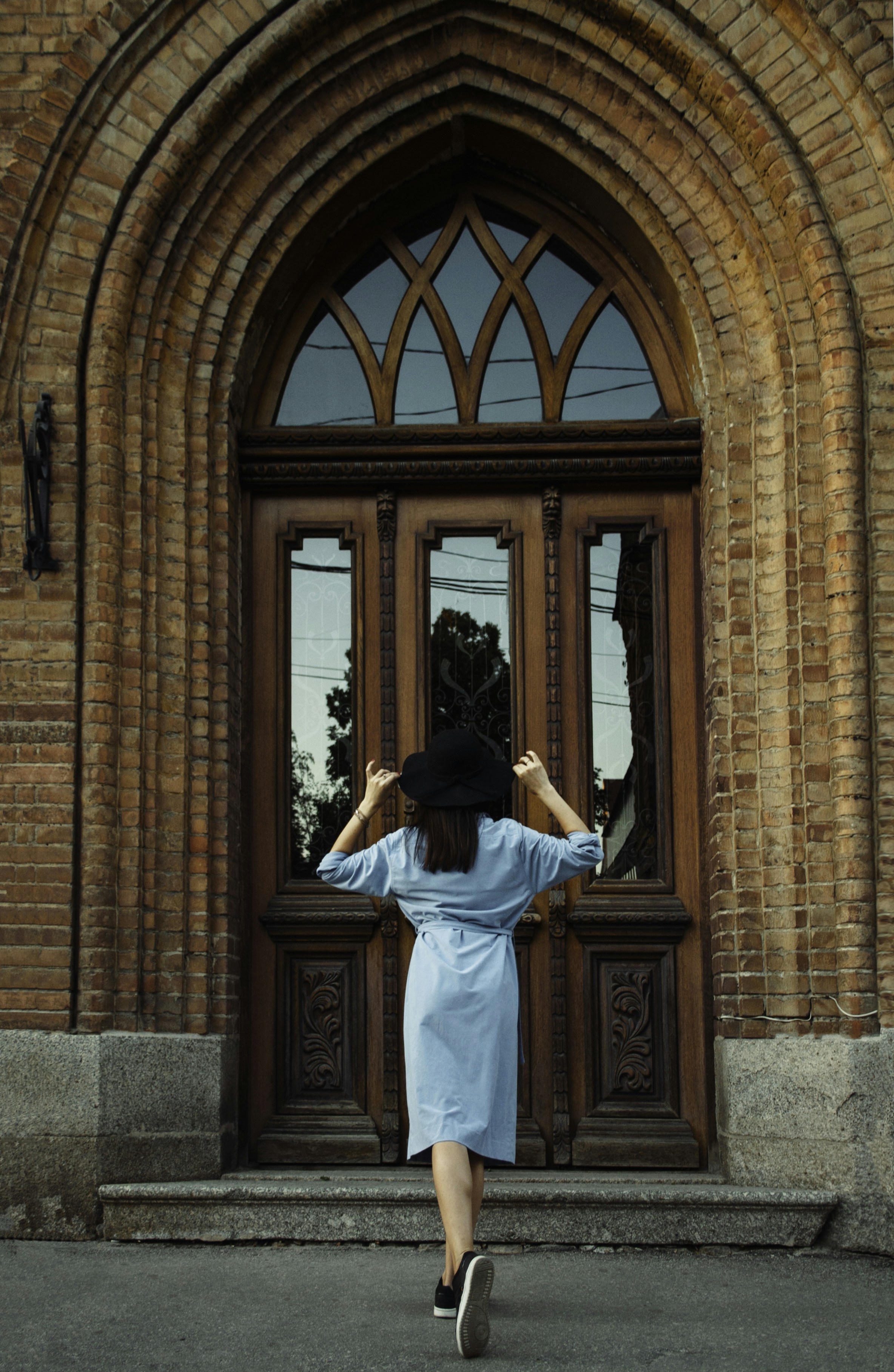 A doorway to charm: the blue dress at the brick arch