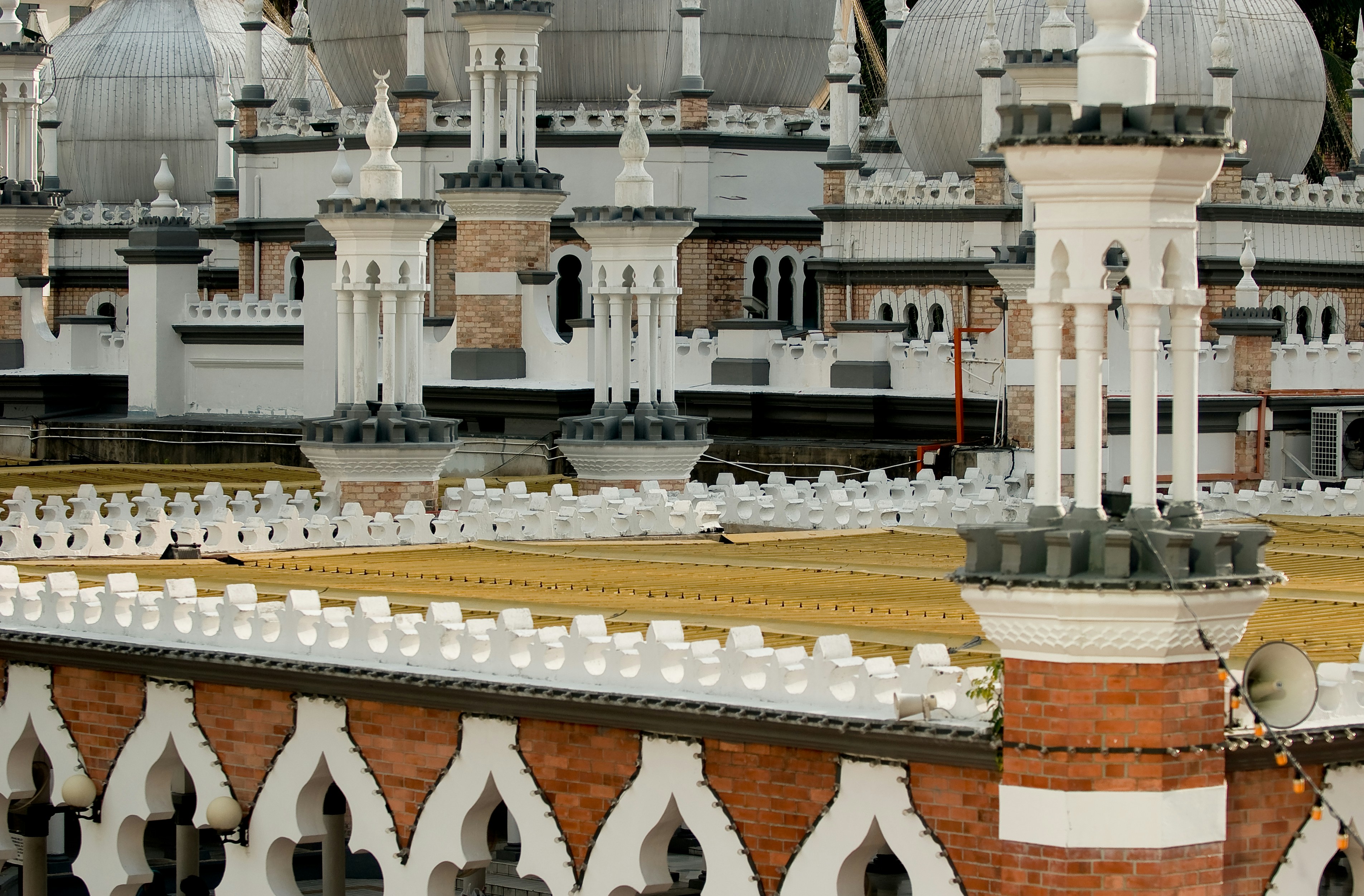 Intricate rooftops of a historic mosque, showcasing a blend of architectural styles with ornate details and vibrant colors.