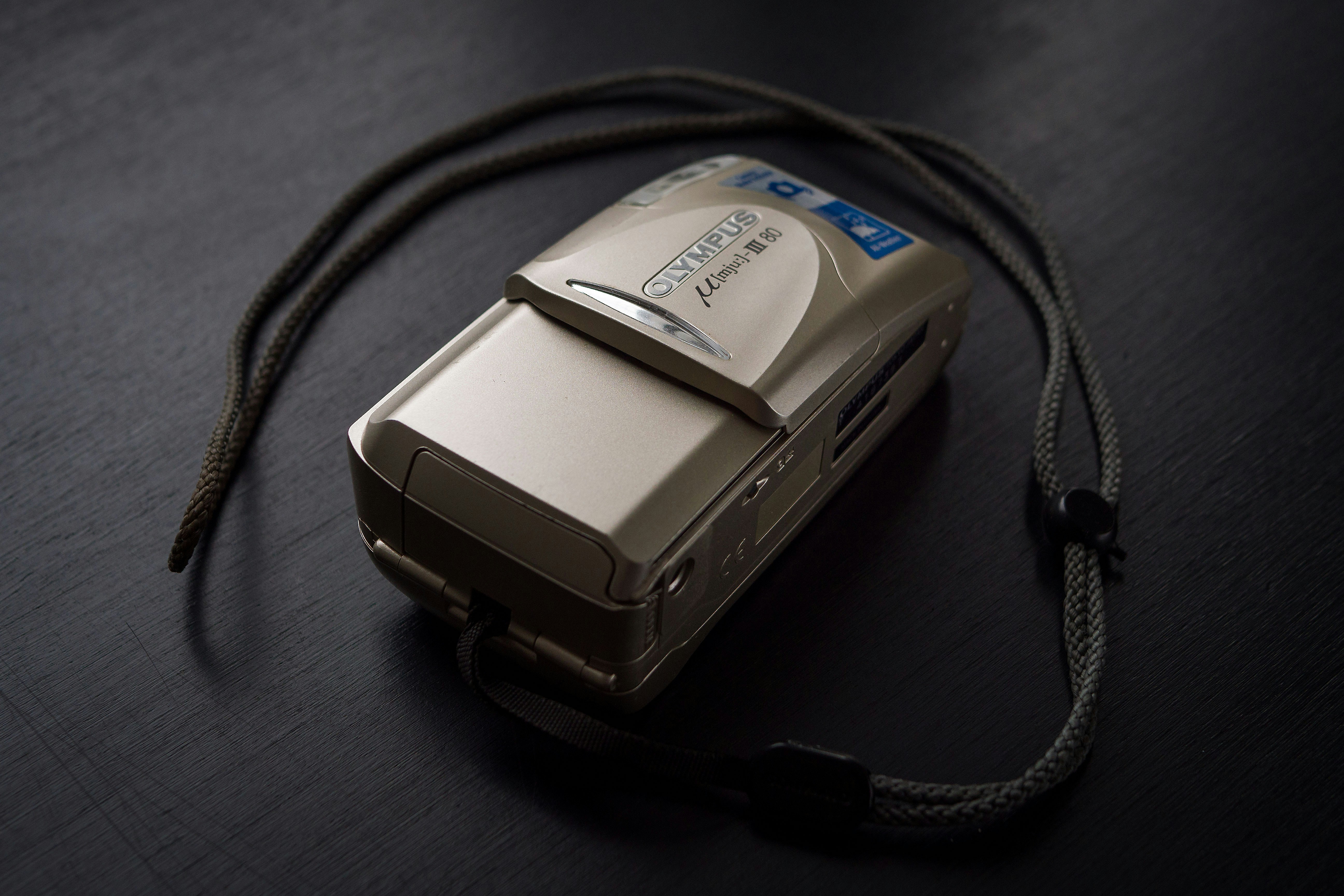 Shallow focus photo of gray Olympus camera on black surface photo ...