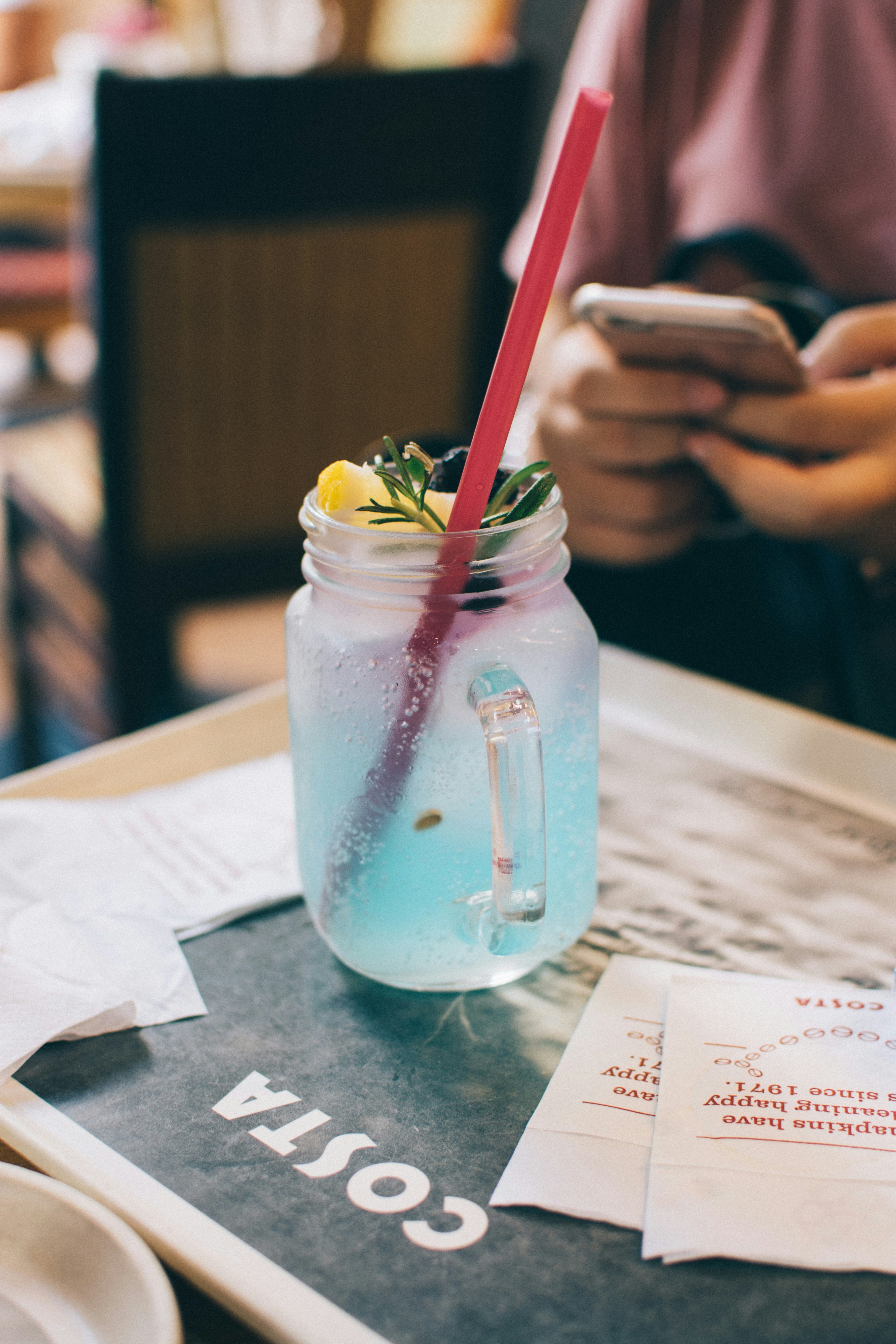 Azure Spritz in a Mason Jar: Lemon Zest, Rosemary, and a Pink Straw in a Café Moment