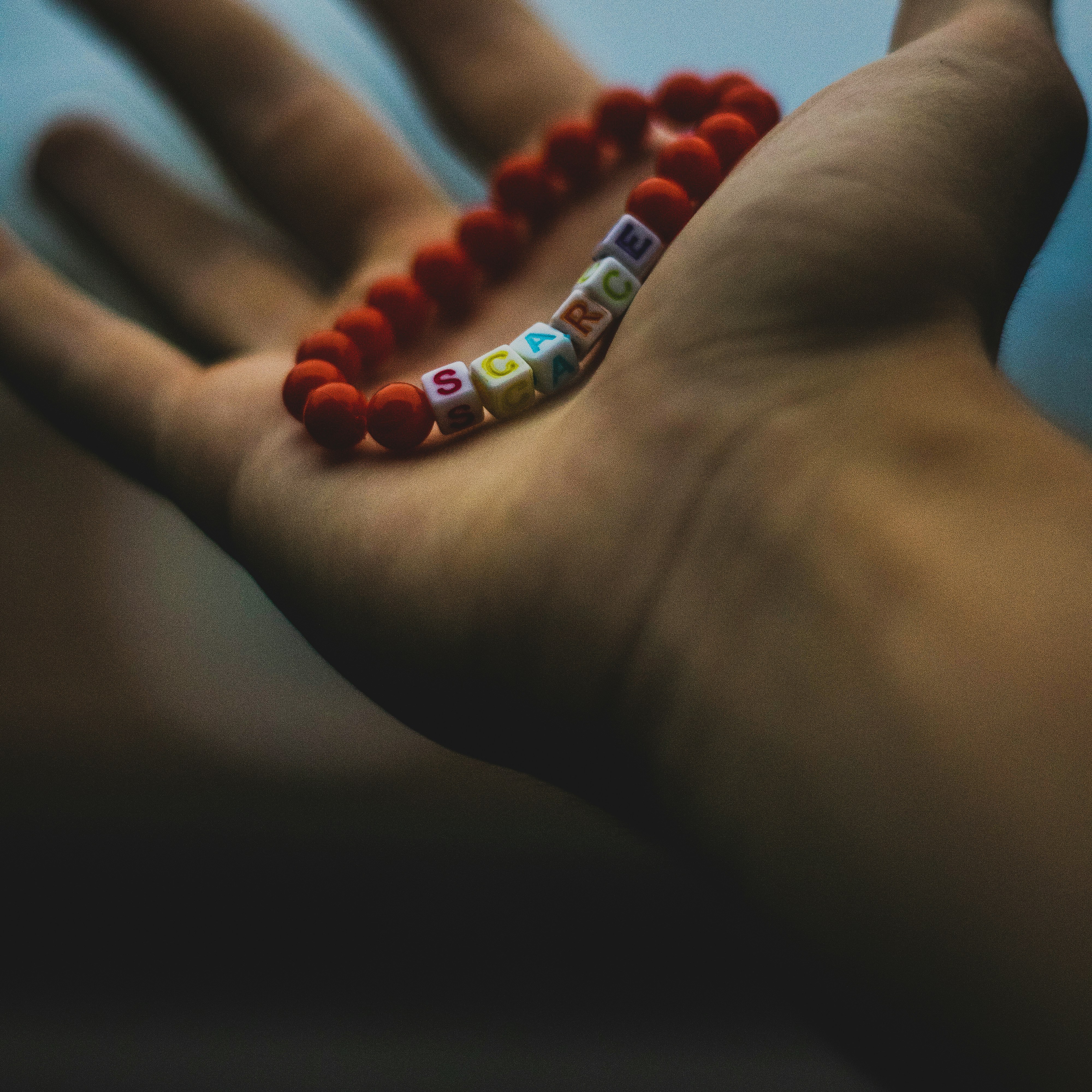 person holding red scarce personalized bracelet