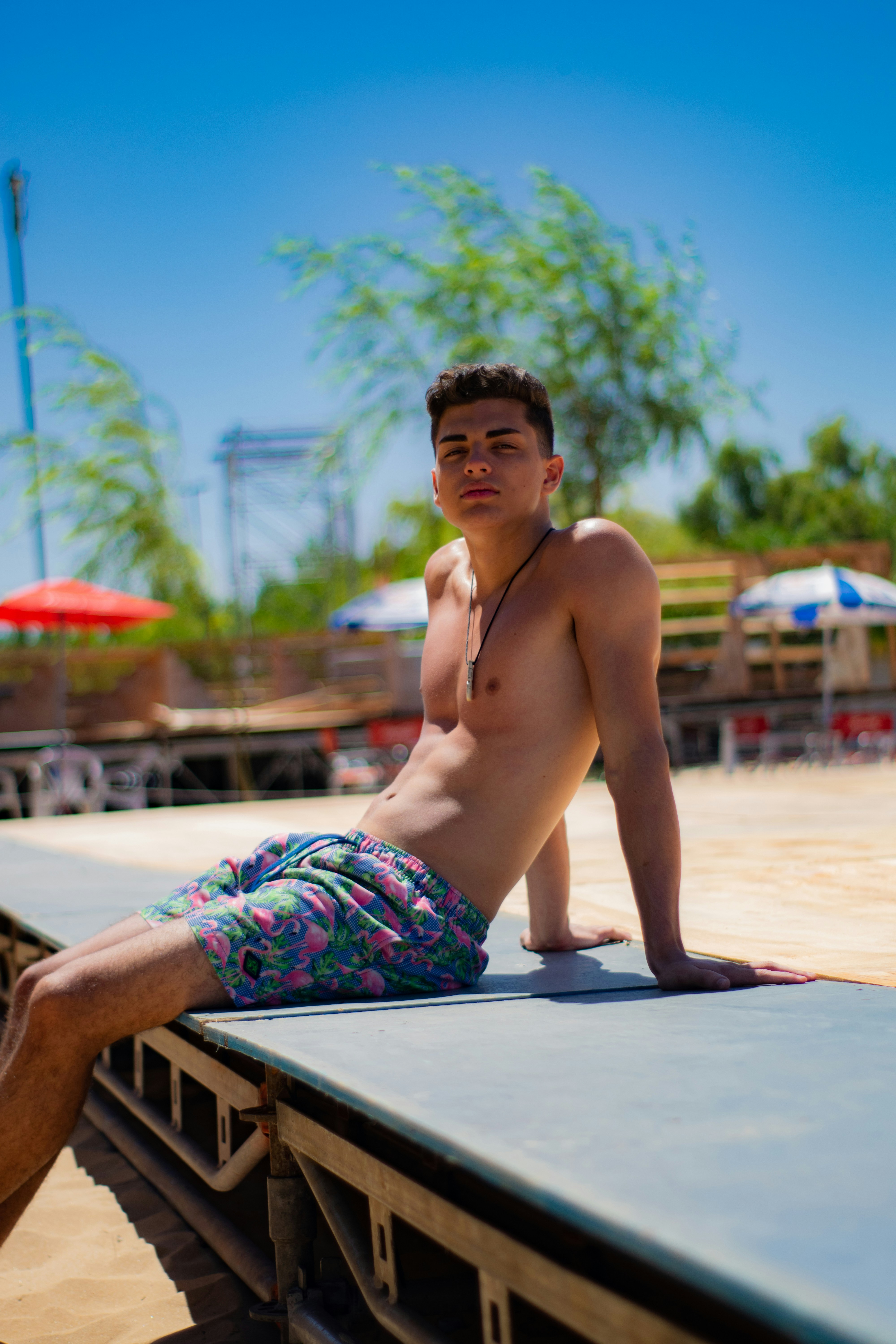 focus photography of man sitting near parasols