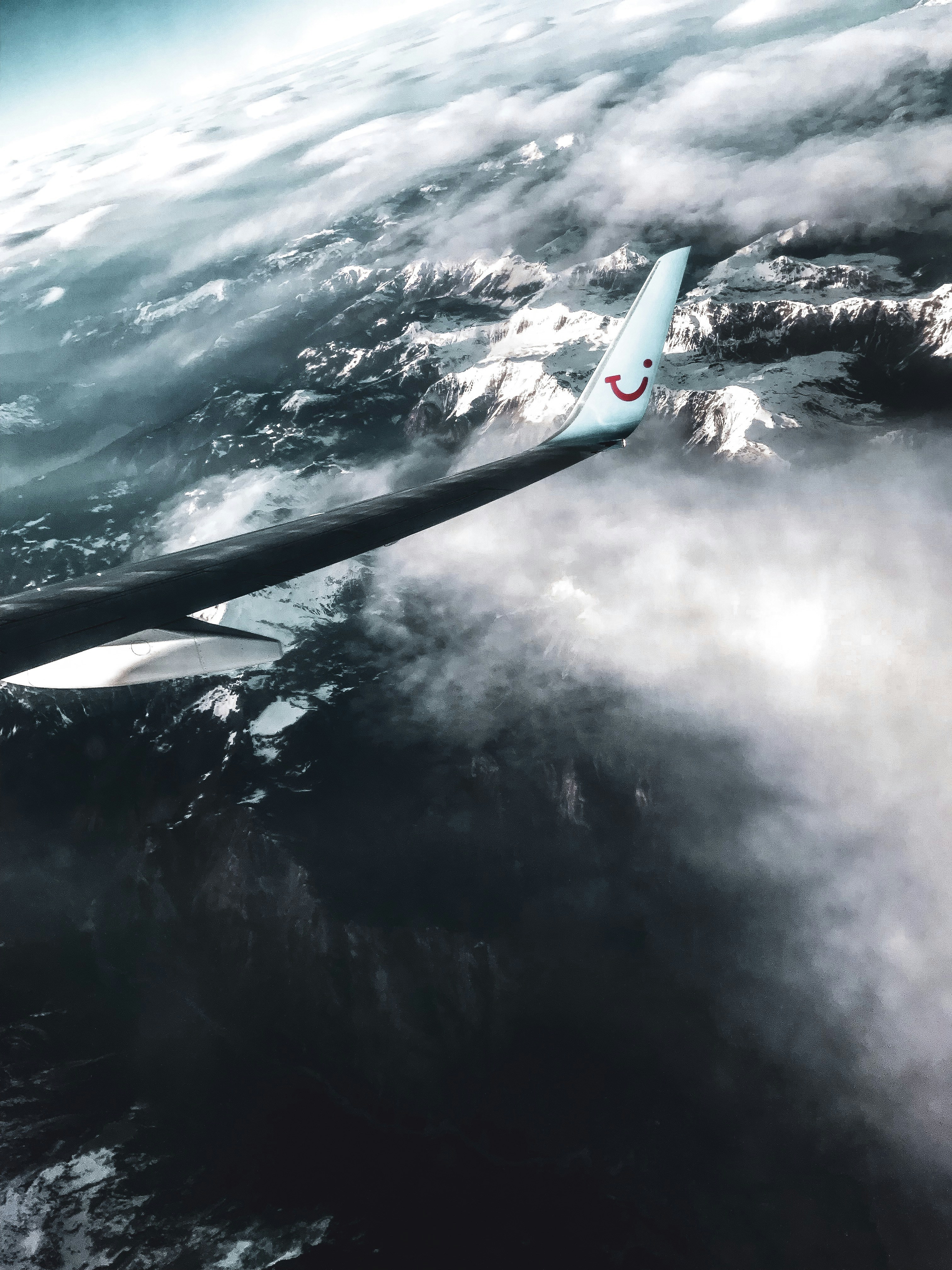 Turquoise Winglet Smile Over Cloud-Swept Peaks