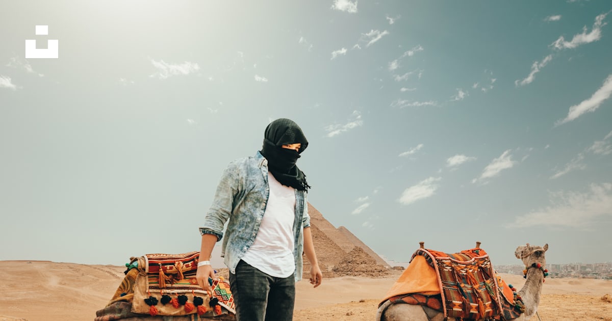 Foto Persona De Pie En El Desierto Cerca De Un Camello En Reposo