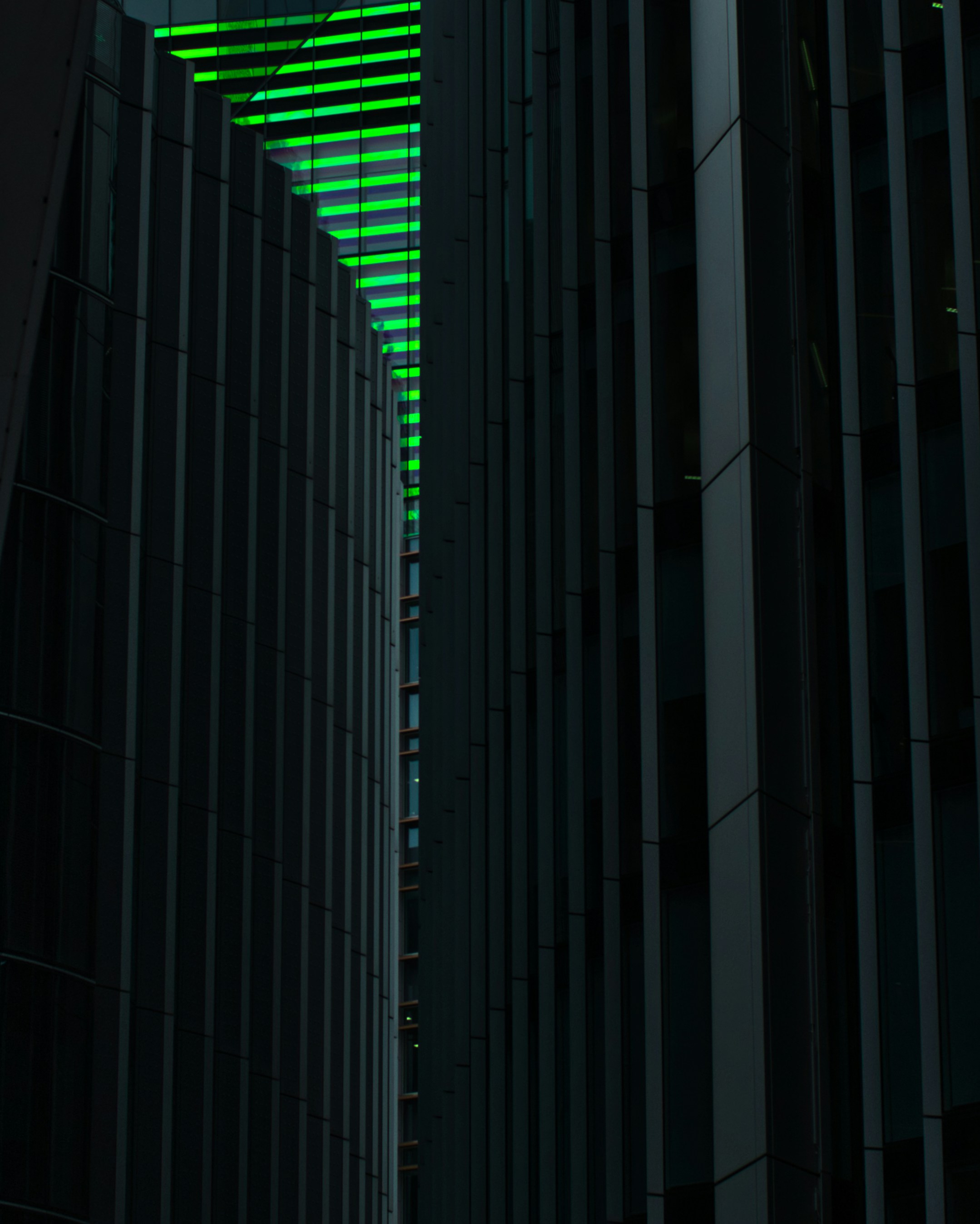 Between Vertical Fins: Neon Green Slats Framing a Skyward Gap