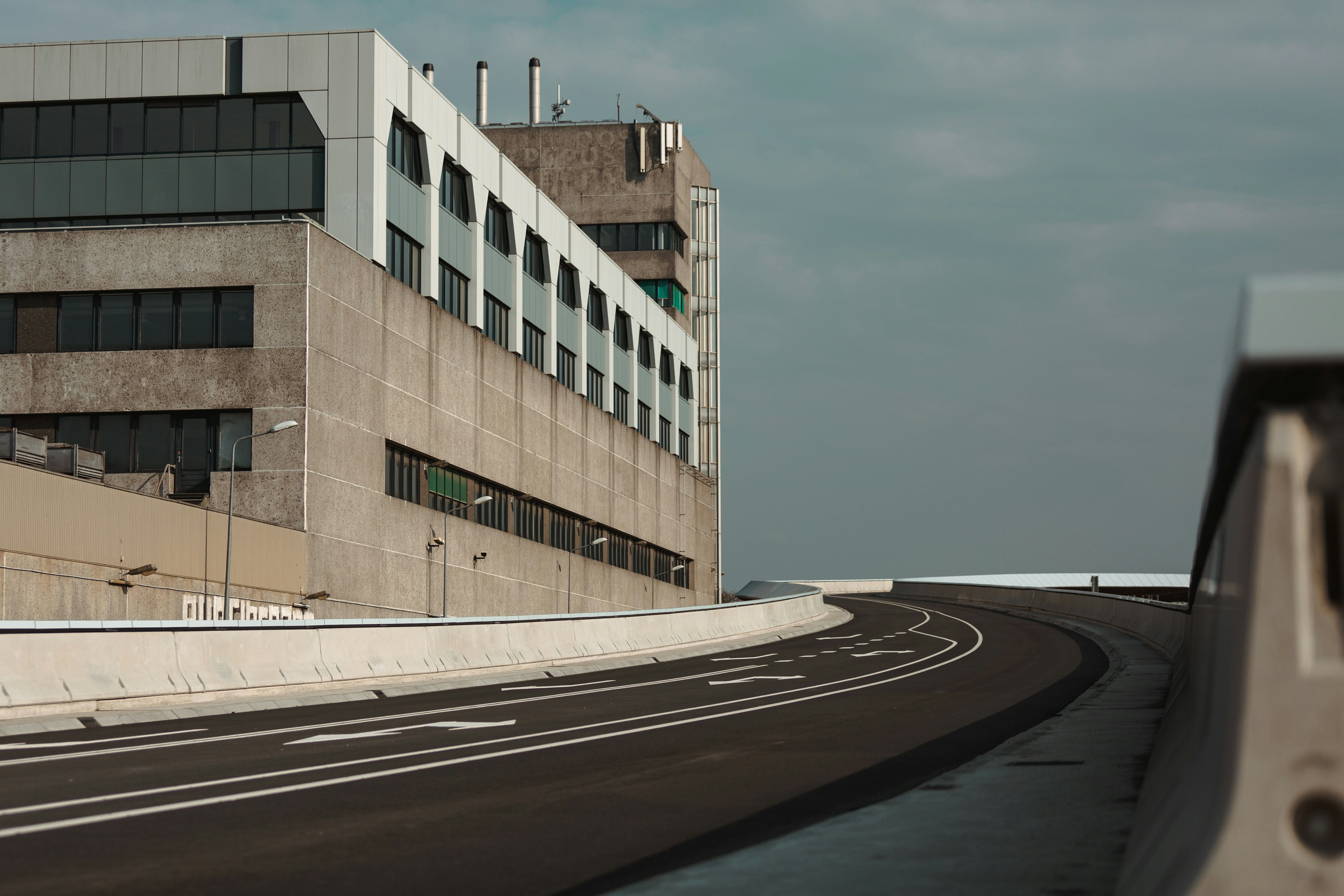 Rooftop Curve: An Asphalt Ribbon Carving Through Concrete Geometry