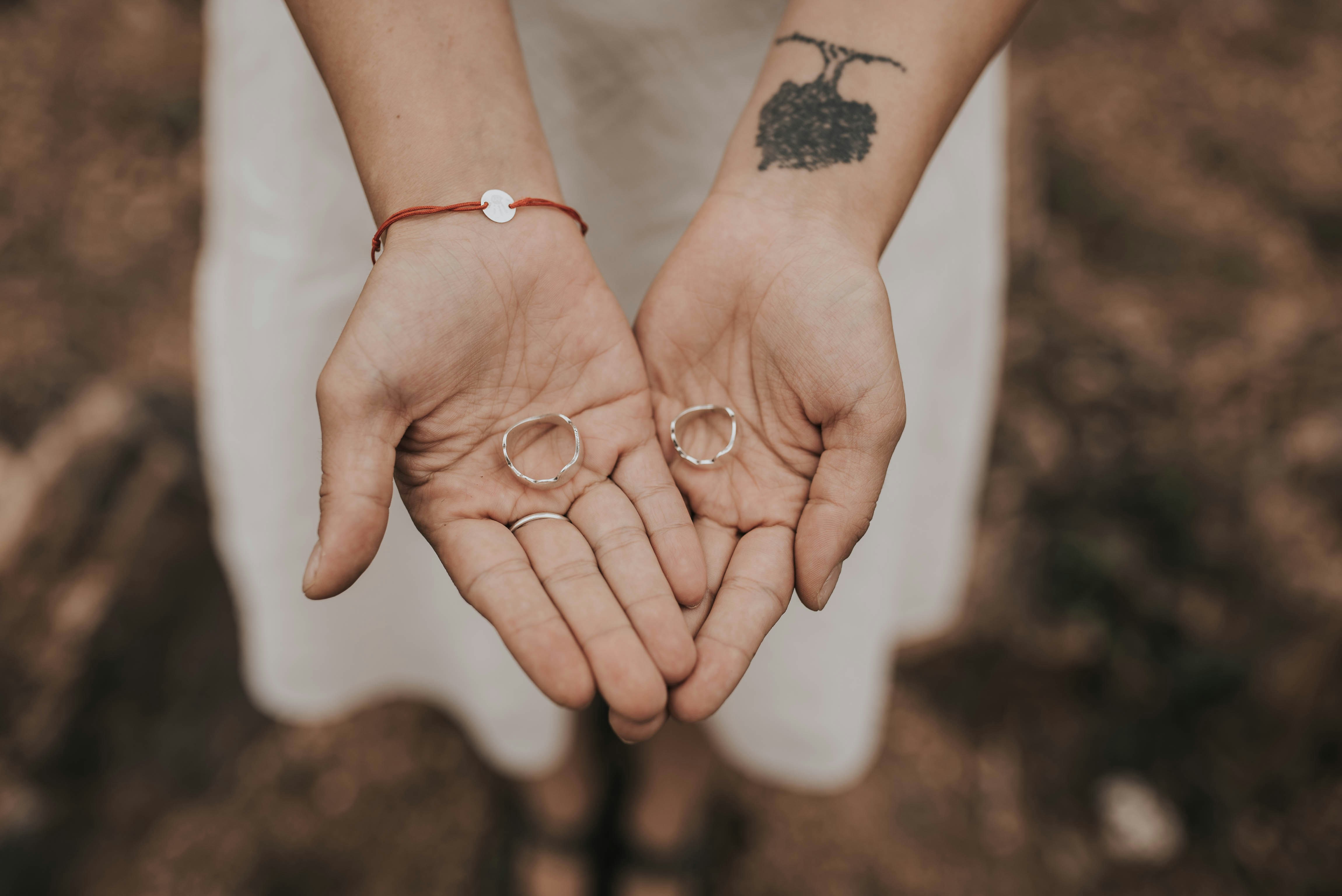 Two gold wedding rings on palm photo – Free Human Image on Unsplash