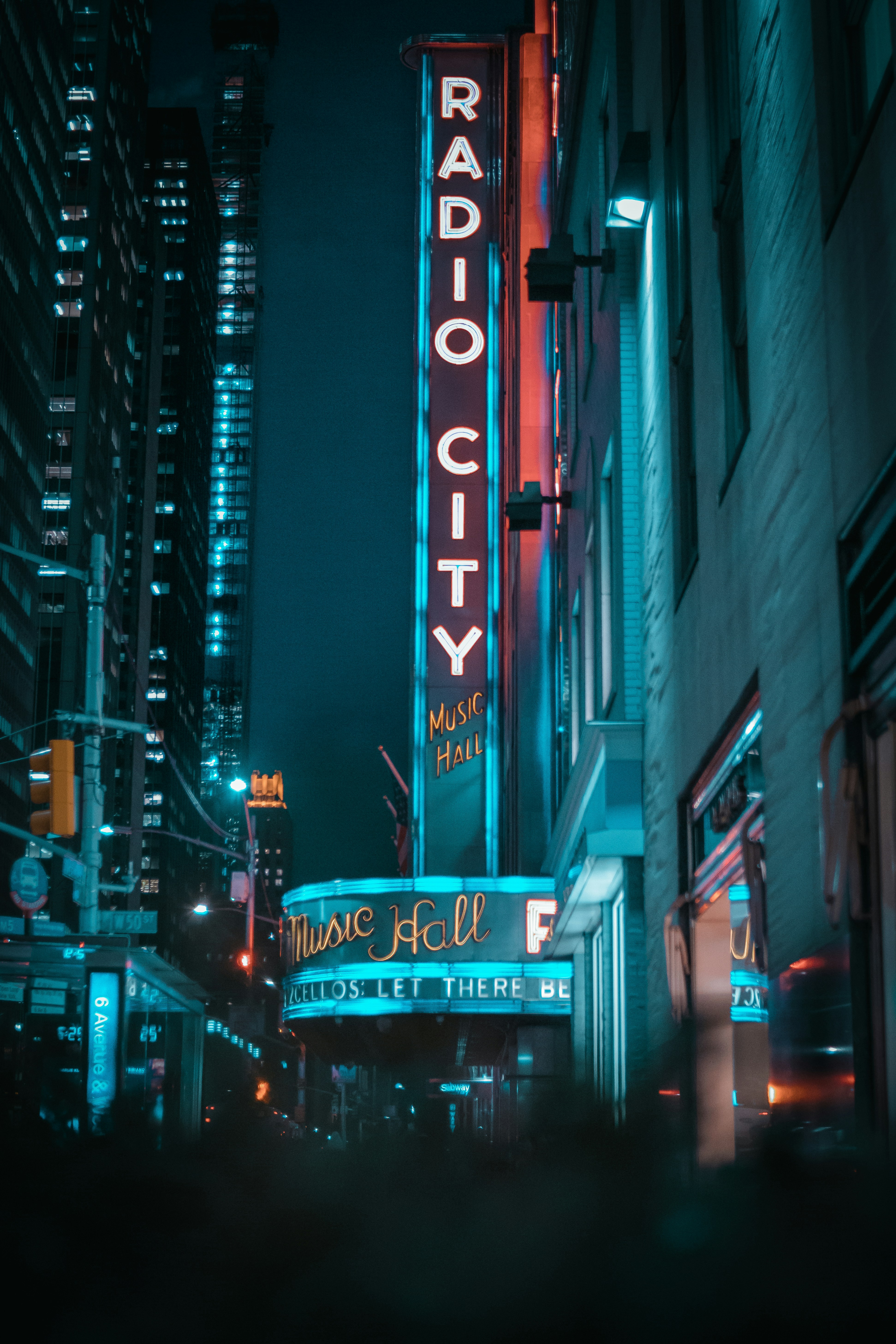 Vibrant neon sign of Radio City Music Hall illuminated against a nighttime urban backdrop, showcasing the iconic venue's allure.