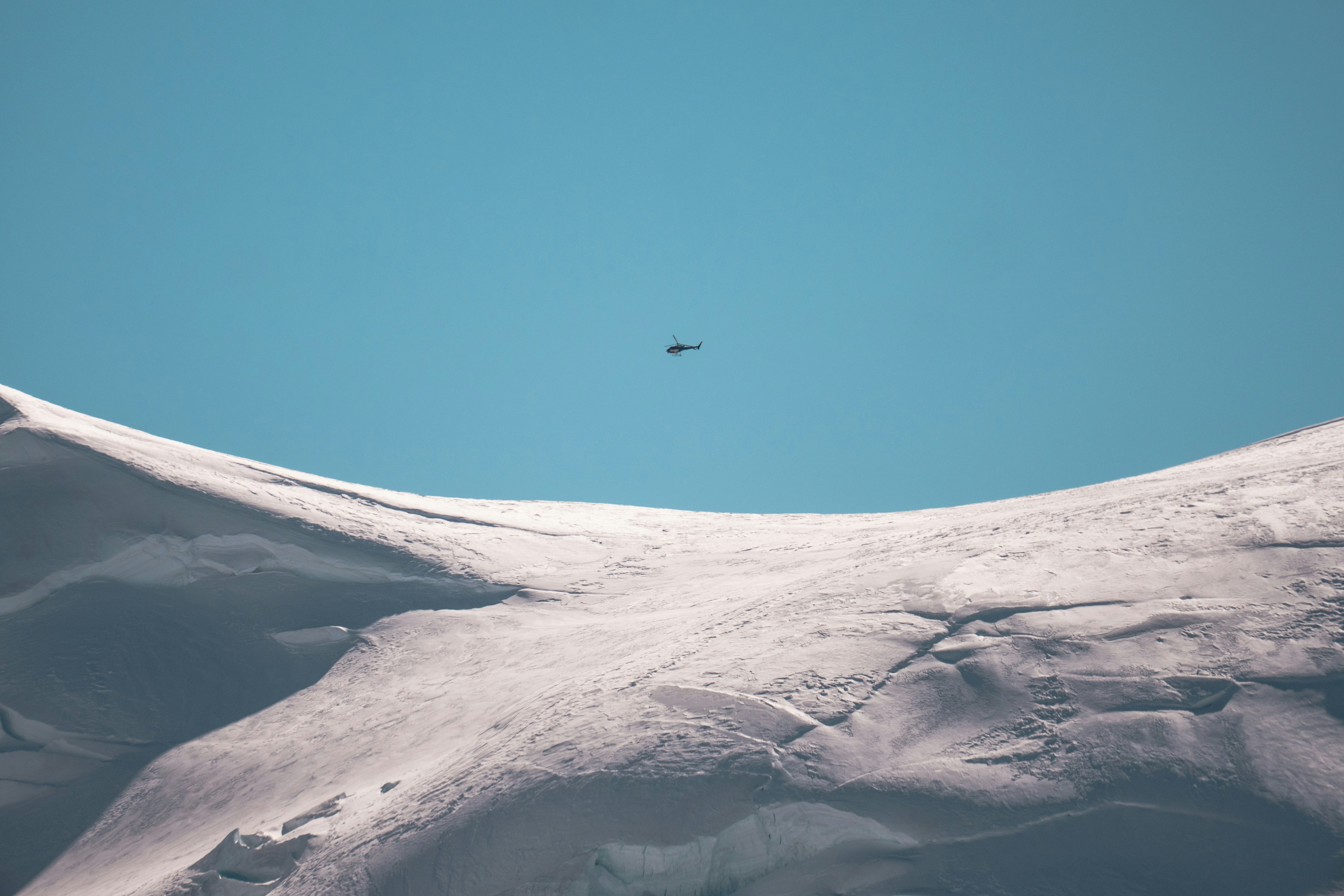 A plane flying over a snow covered mountain photo – Free Snow Image on ...