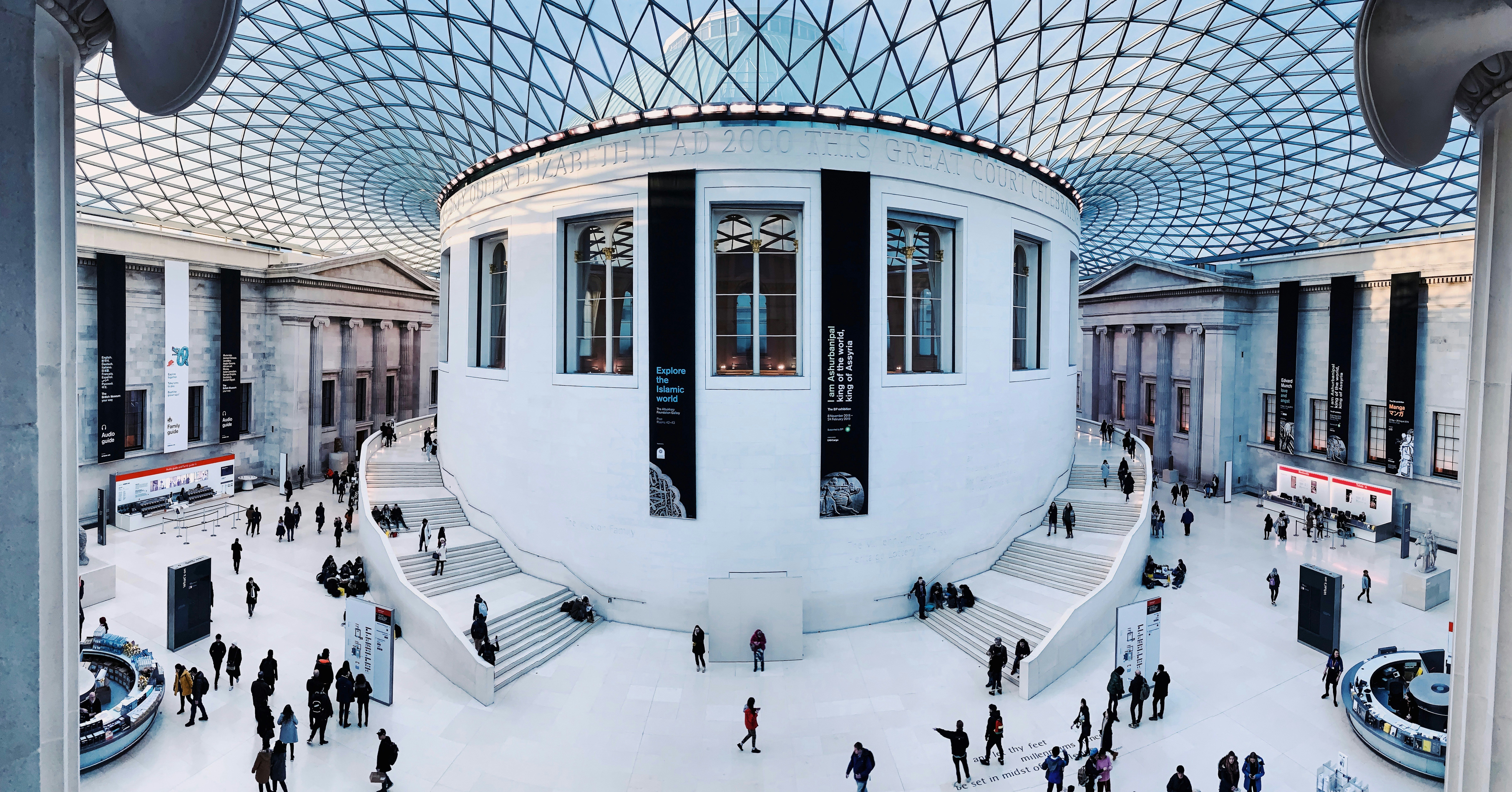 A group of people walking around a building photo – Free City Image on ...