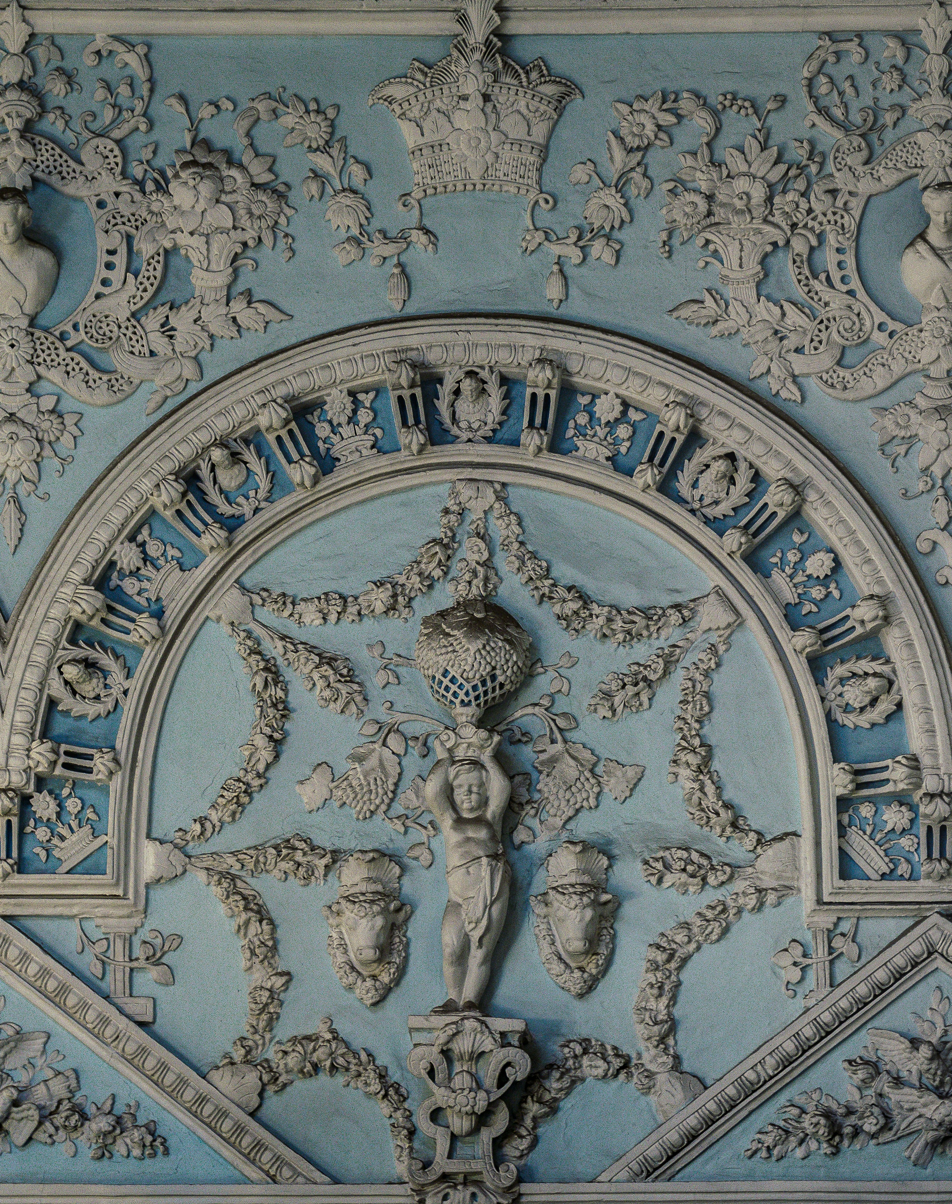 Ornate Blue Façade: A Crowned Archway with Classical Sculptures