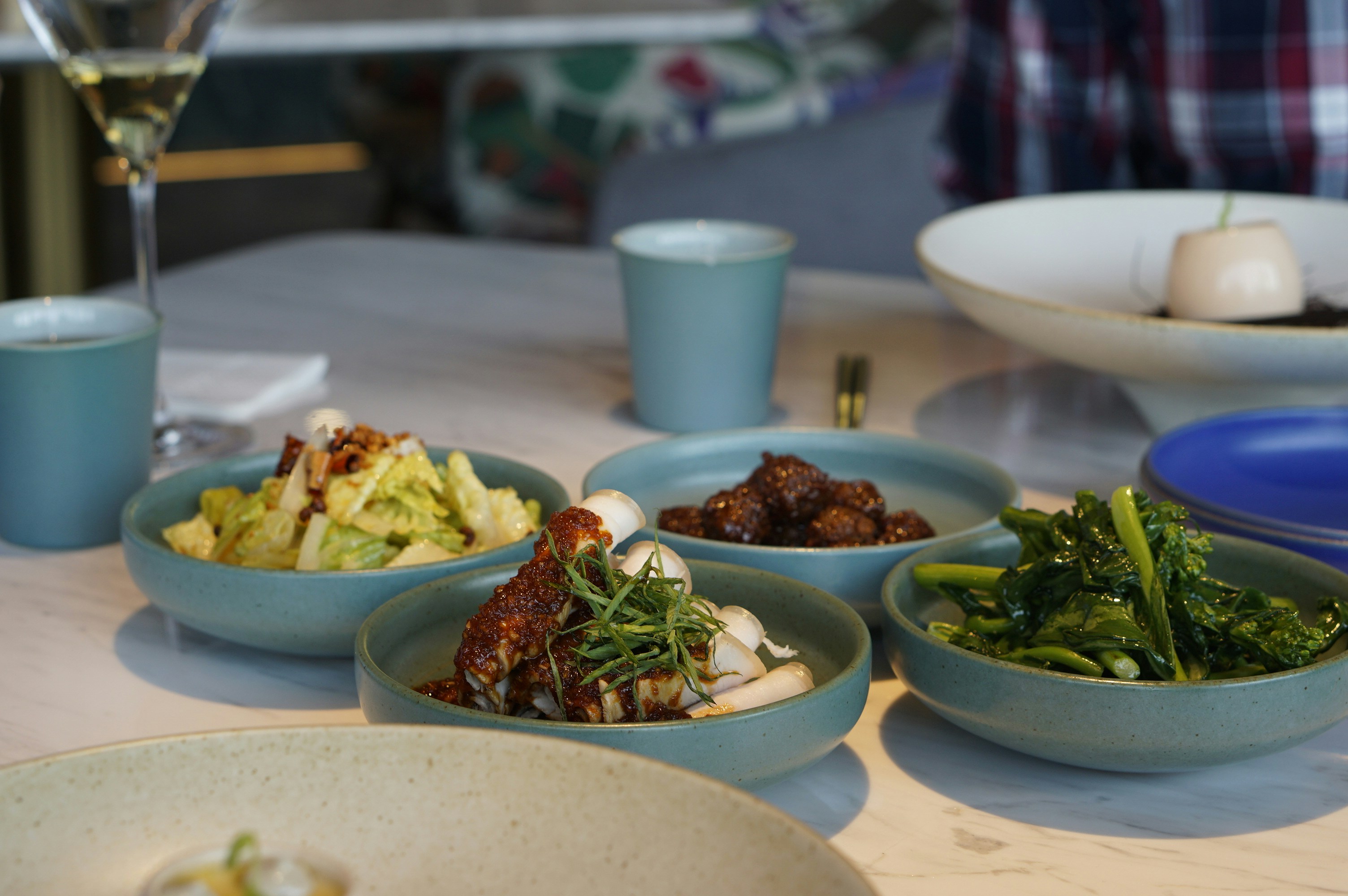 Assorted Asian-inspired dishes on a light marble table