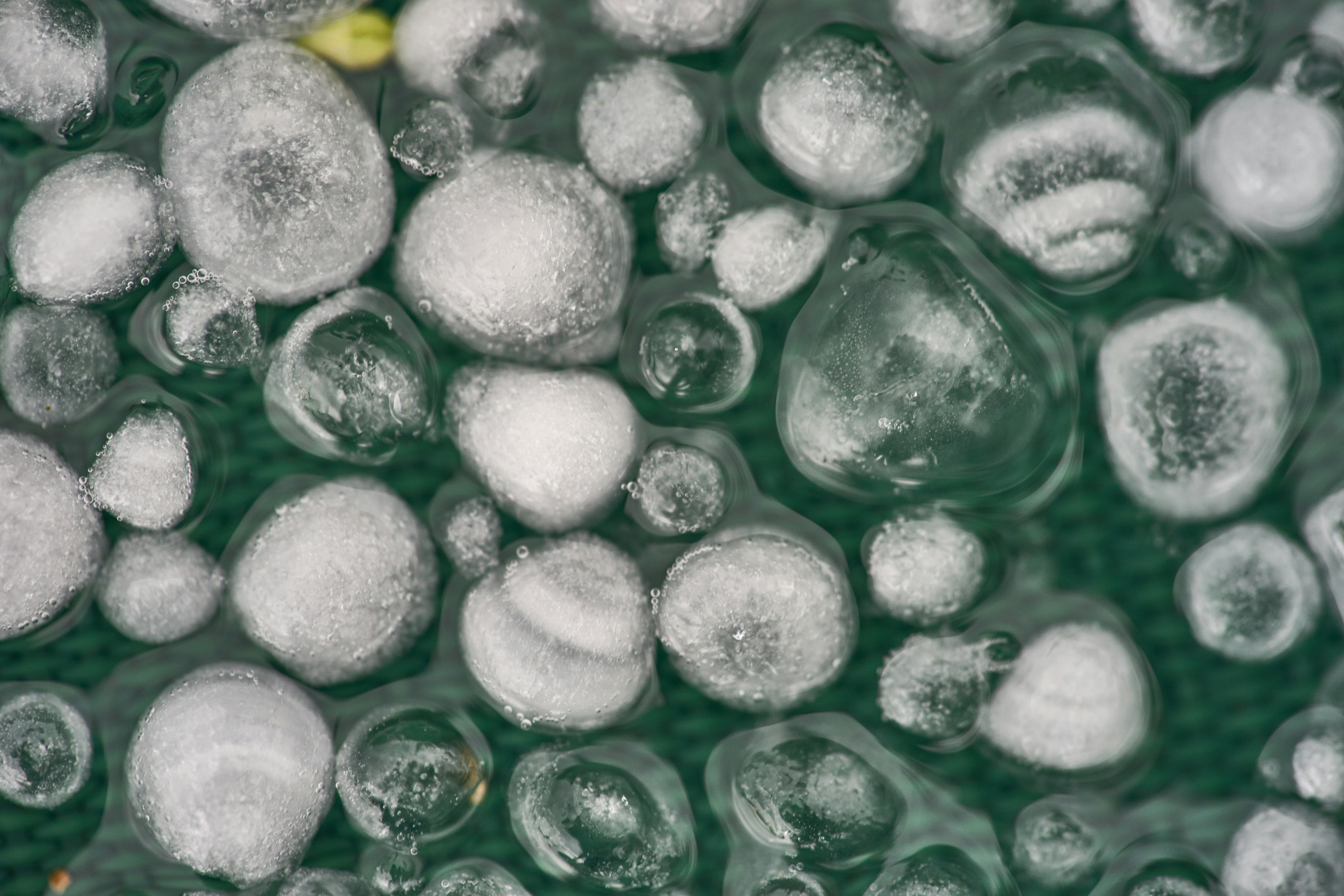 hail | a close up of ice bubbles on a green surface
