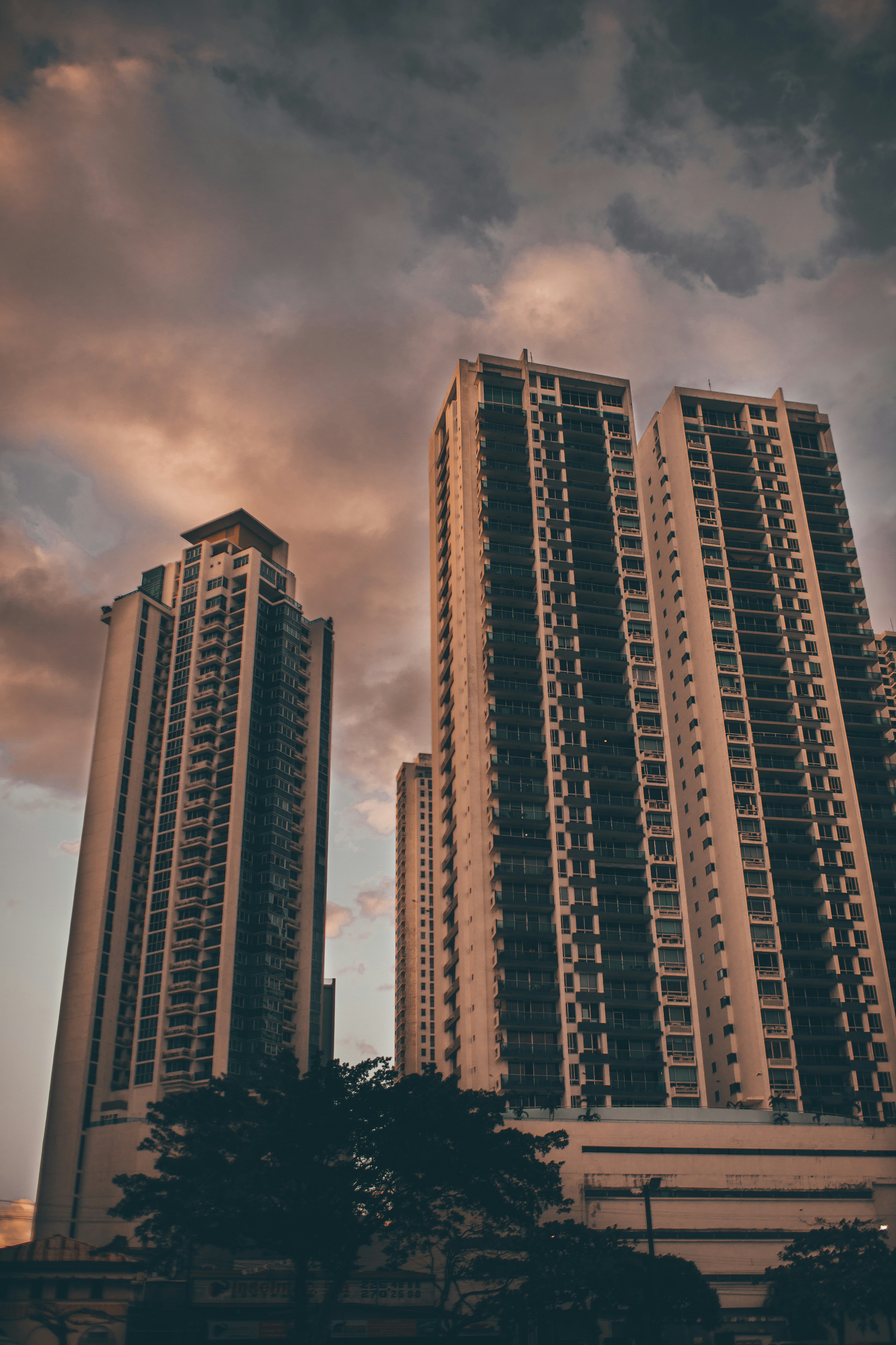Two brown and black high rise buildings under grey cloudy sky photo ...