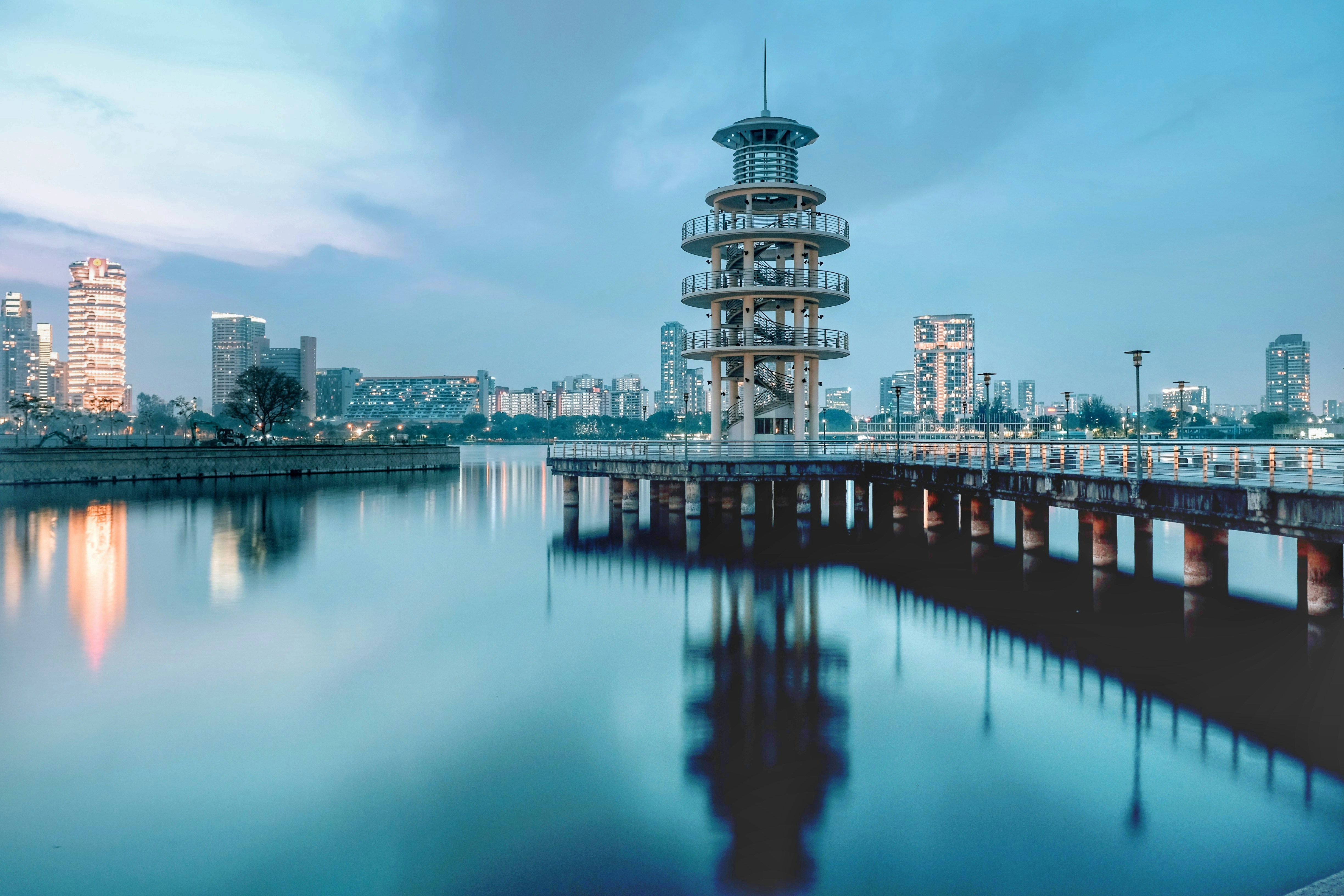 Circular Pier Tower at Blue Hour: City Reflections on Quiet Water