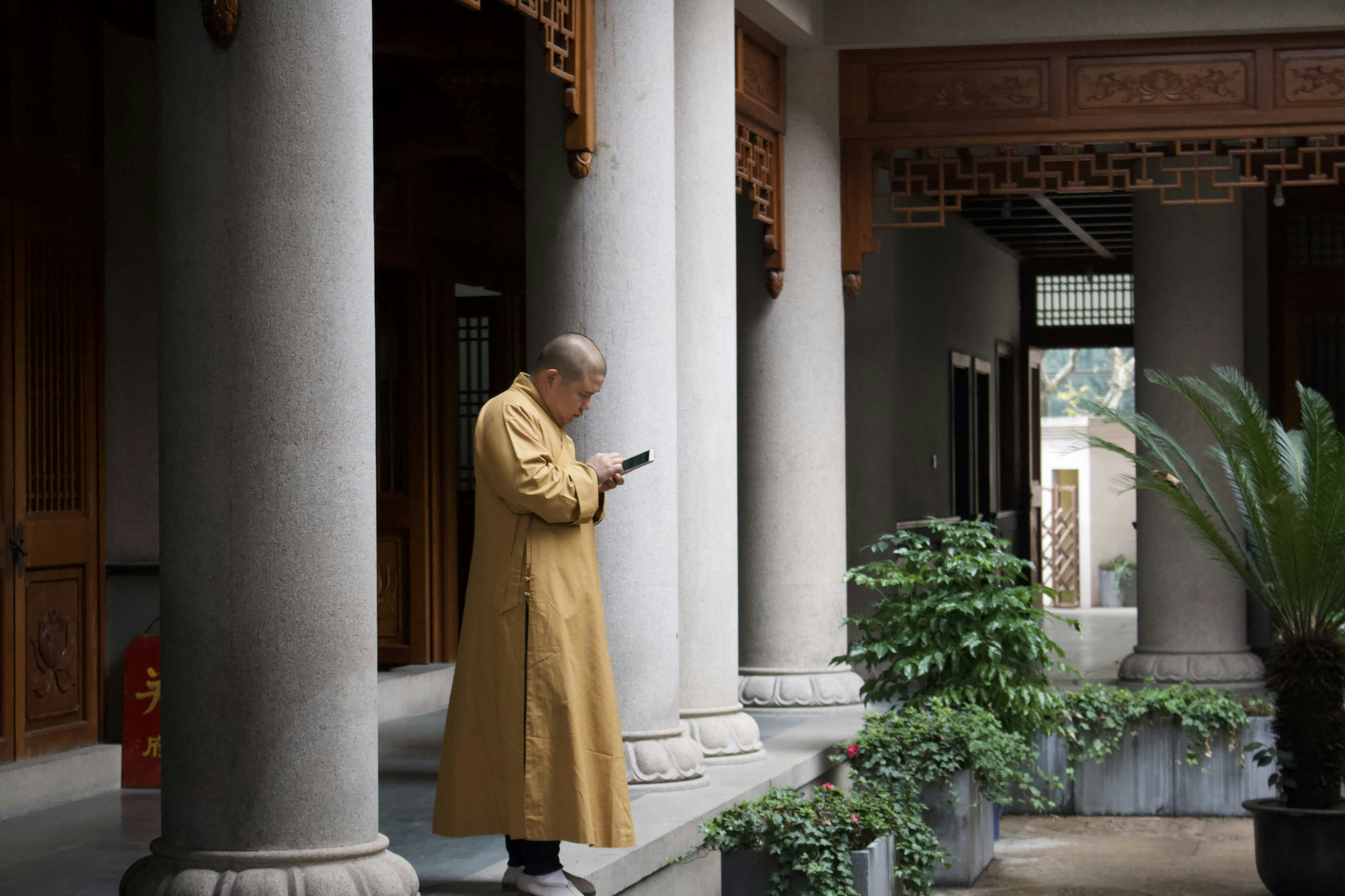 Monk in Quiet Courtyard, Focused on a Message