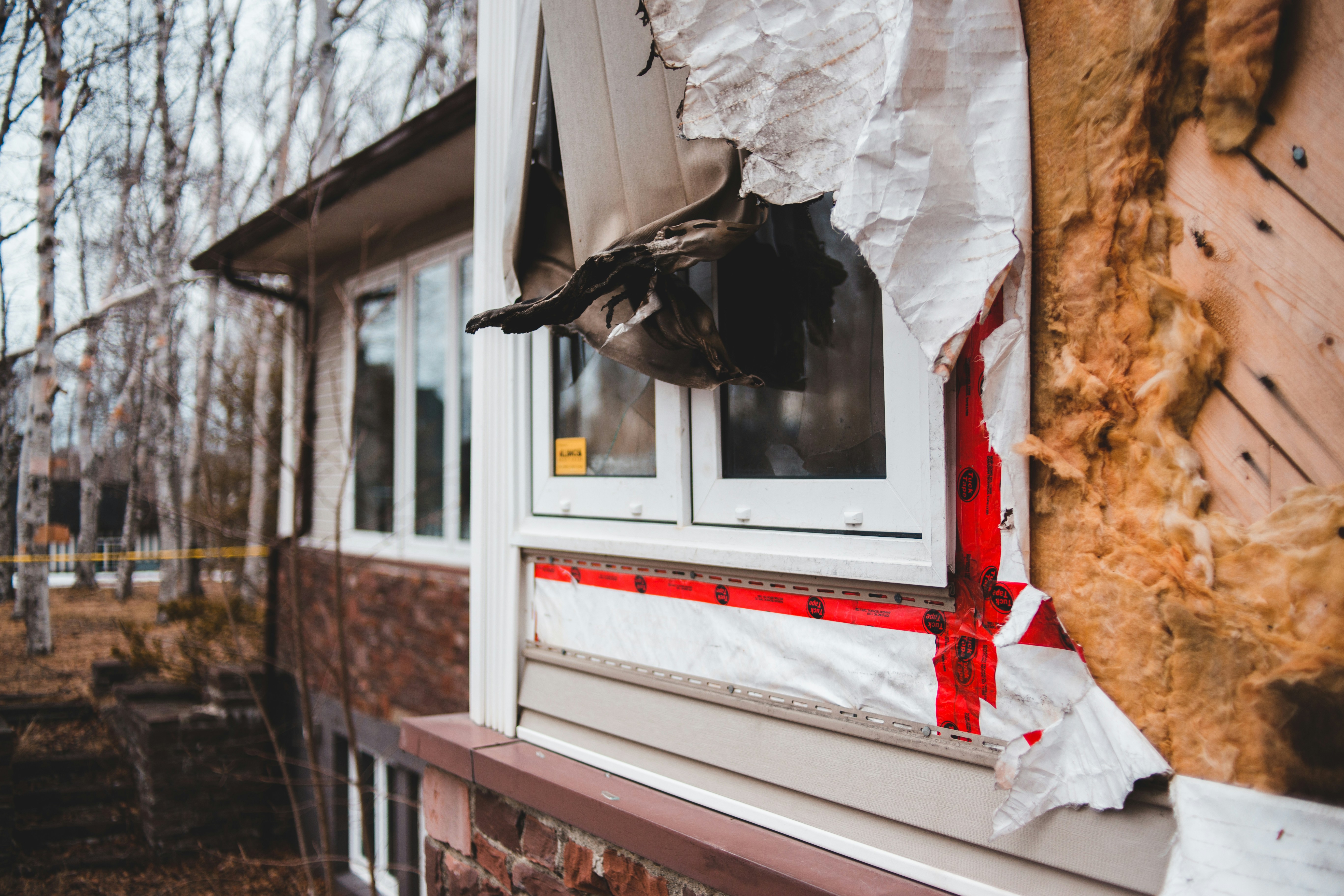 Torn Insulation and Red-Taped Window: Facade in Quiet Decay