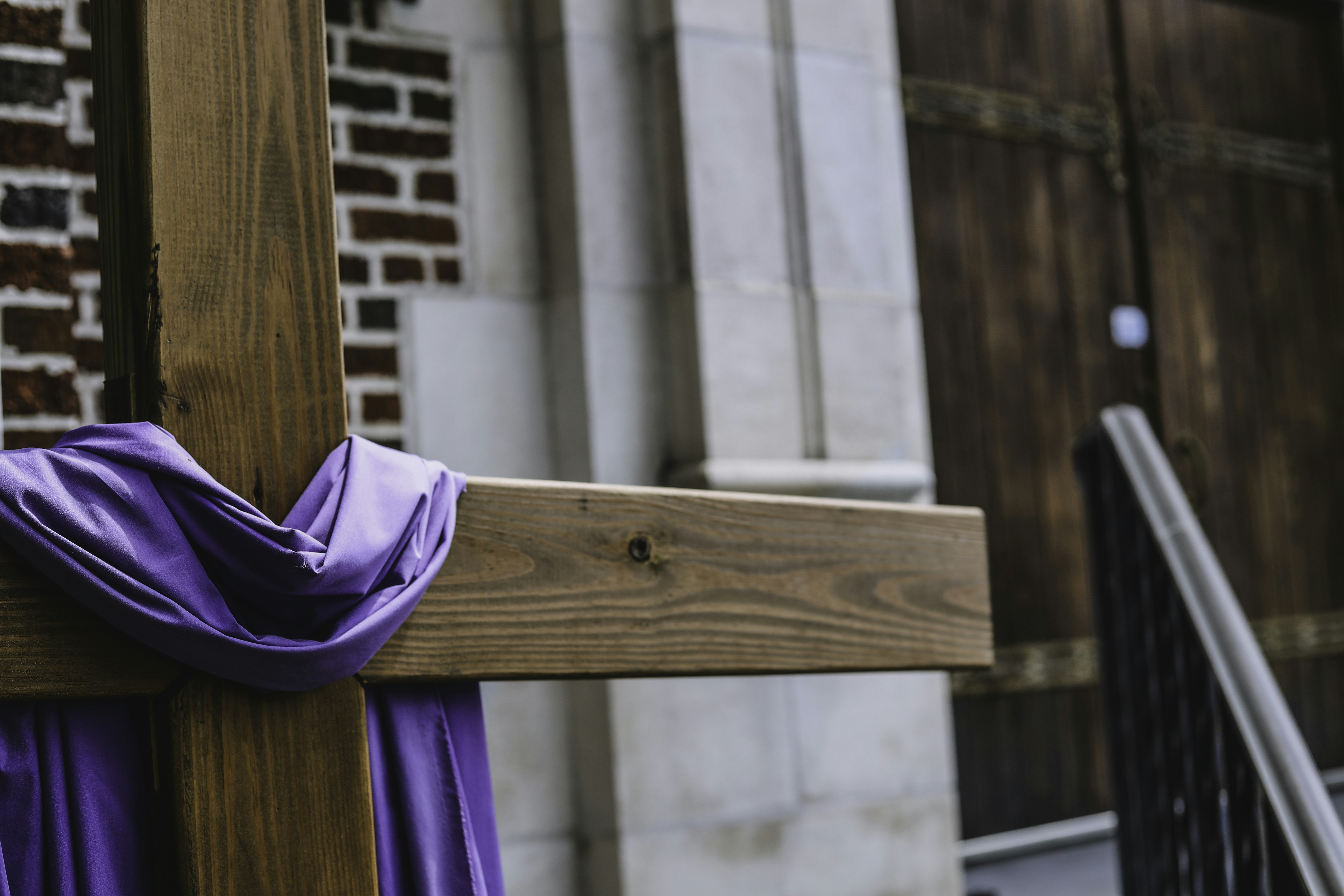 Violet Draped Cross Anchored to a Brick Church Facade