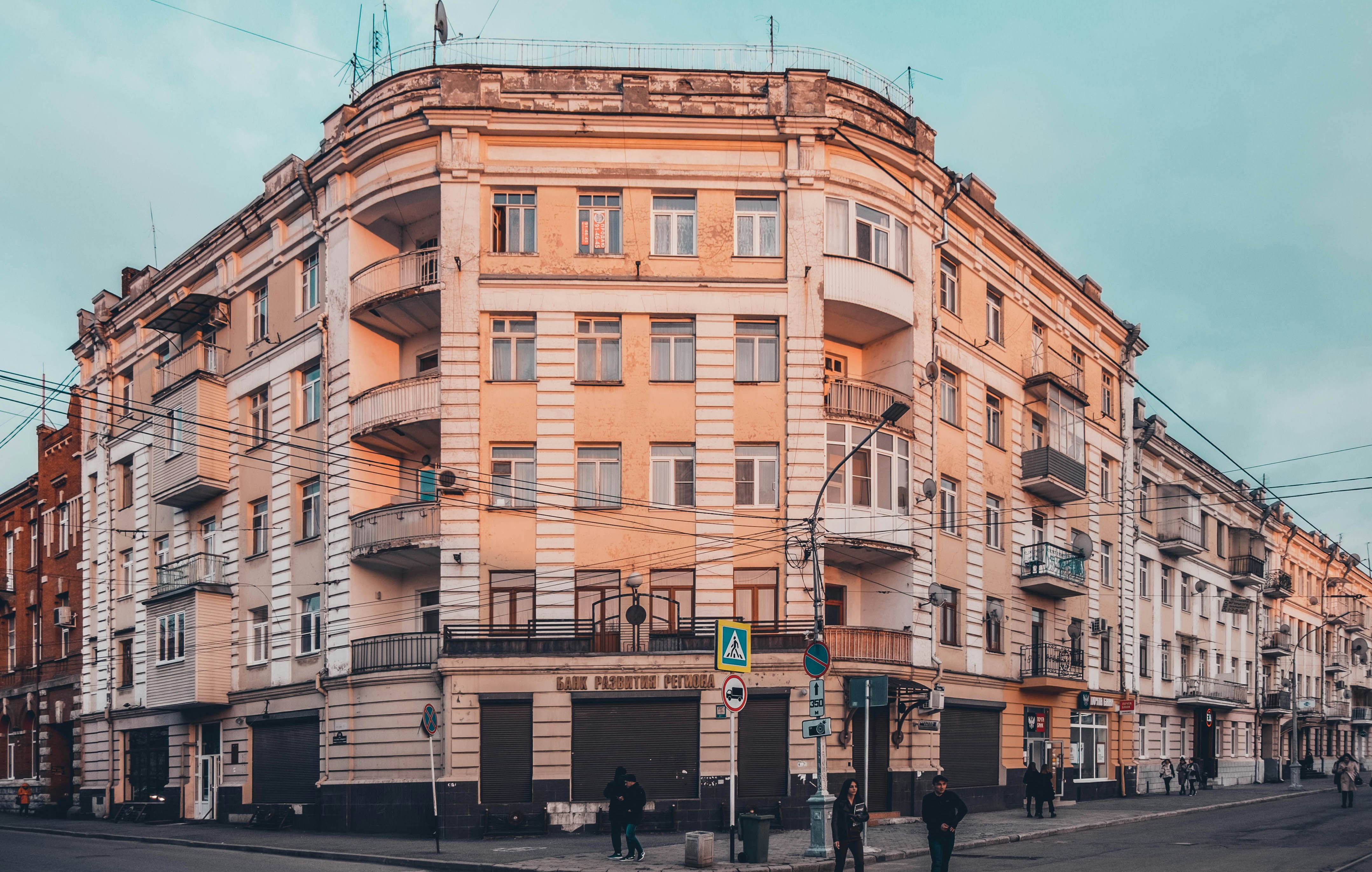 Historic building with art deco elements and warm sunset hues on a city corner.