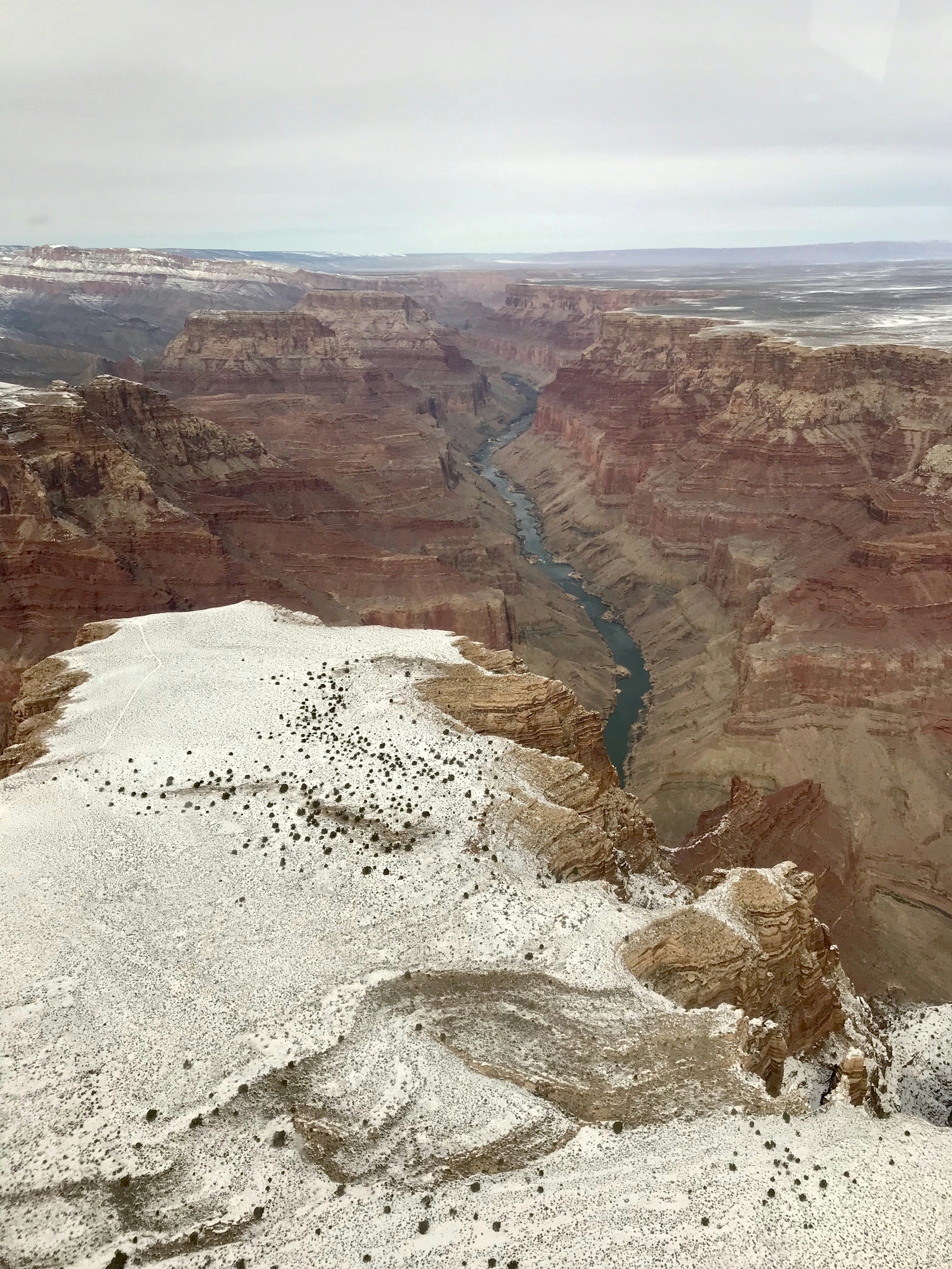 Rim to Canyon: A Snow-Dusted Edge Over a Winding Blue River