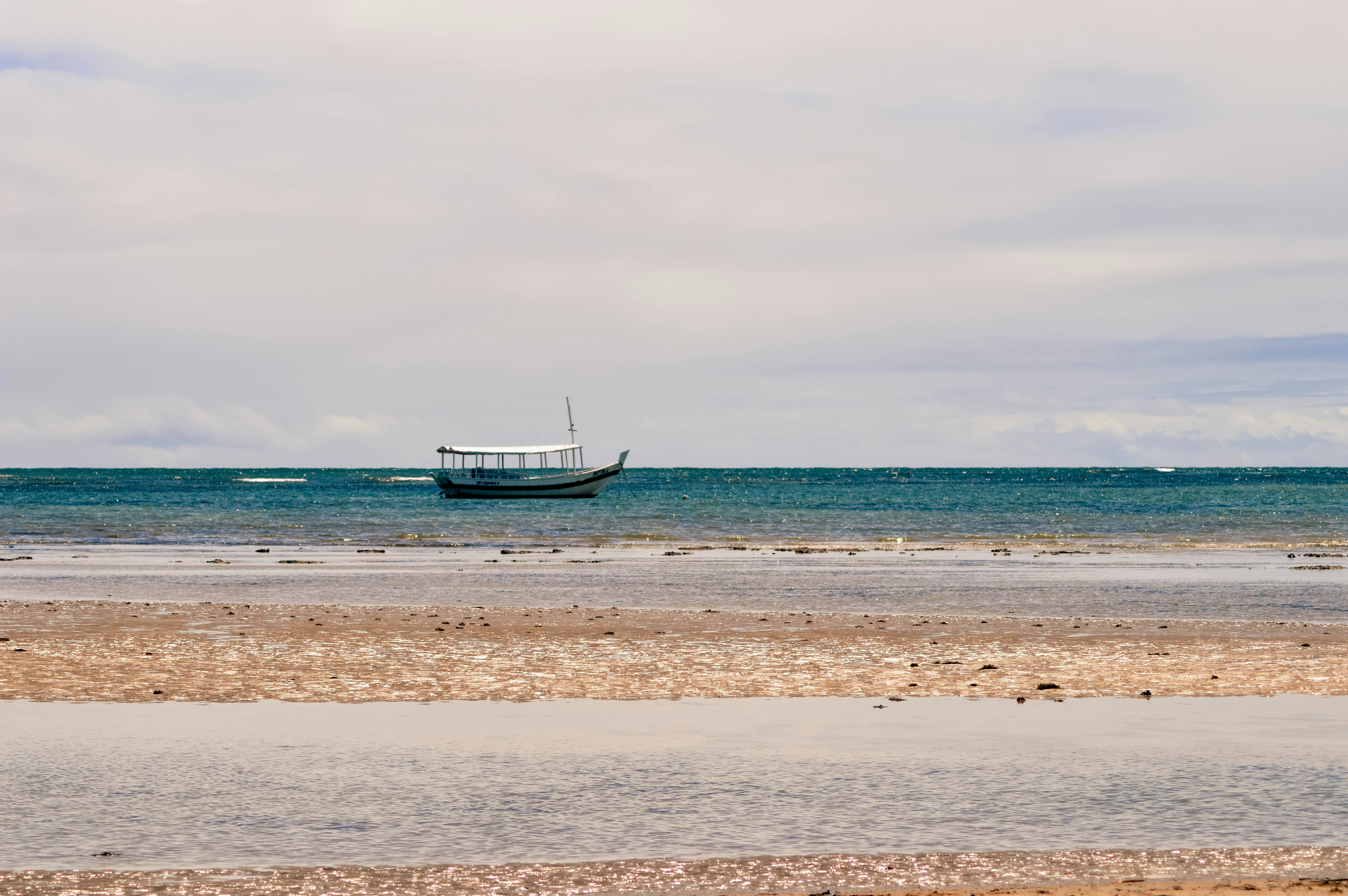 Lone Boat on a Calm Horizon, Touched by Salt-Tinted Light