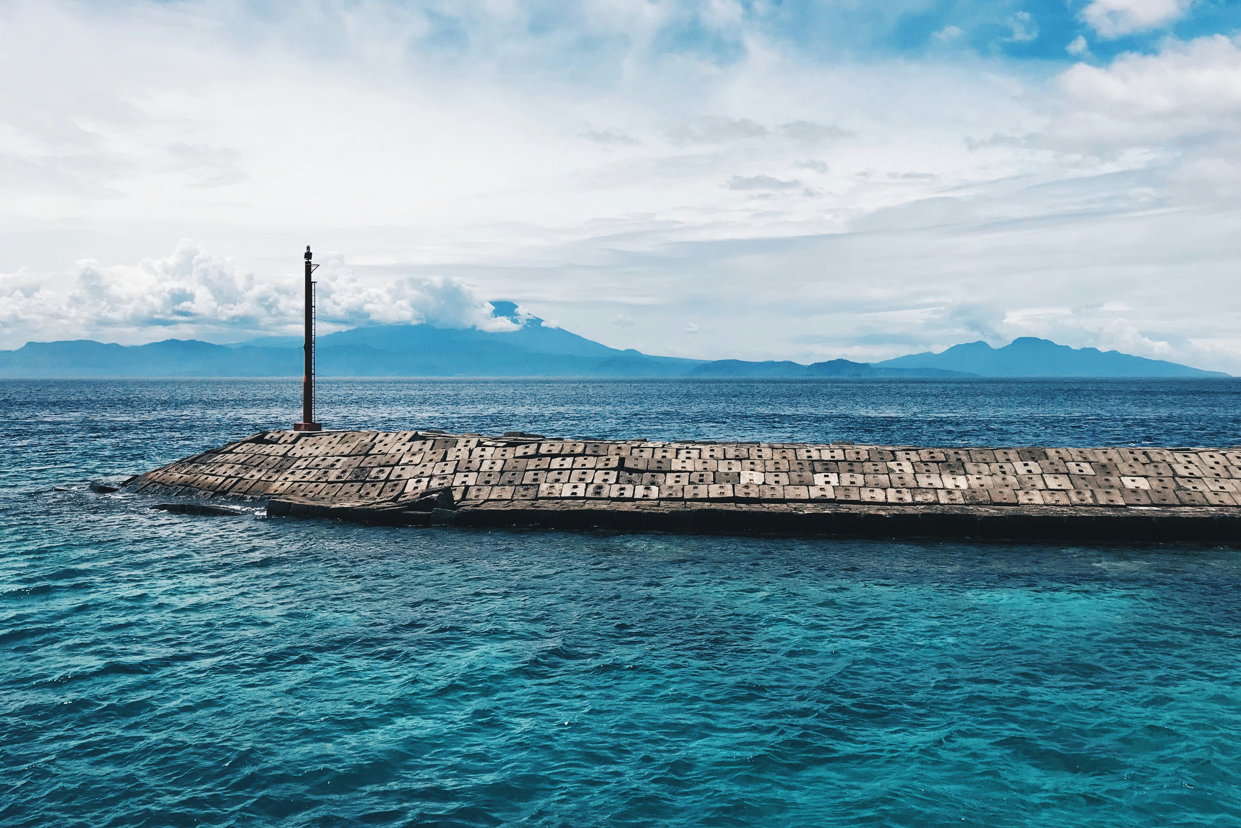 Black port between body of water under white cloudy sky photo – Free ...