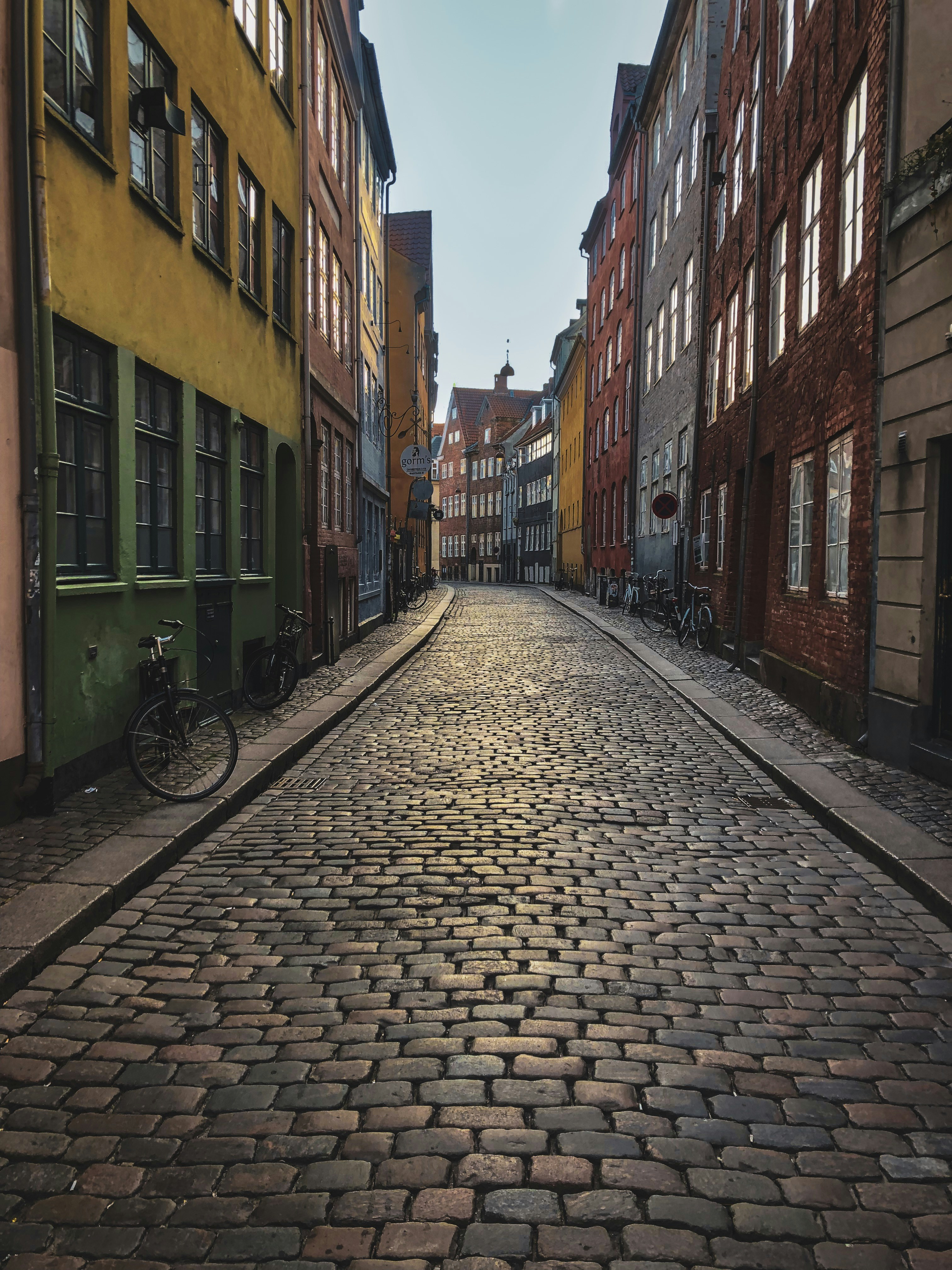 Charming cobblestone street flanked by colorful buildings, inviting exploration in a quaint urban setting.