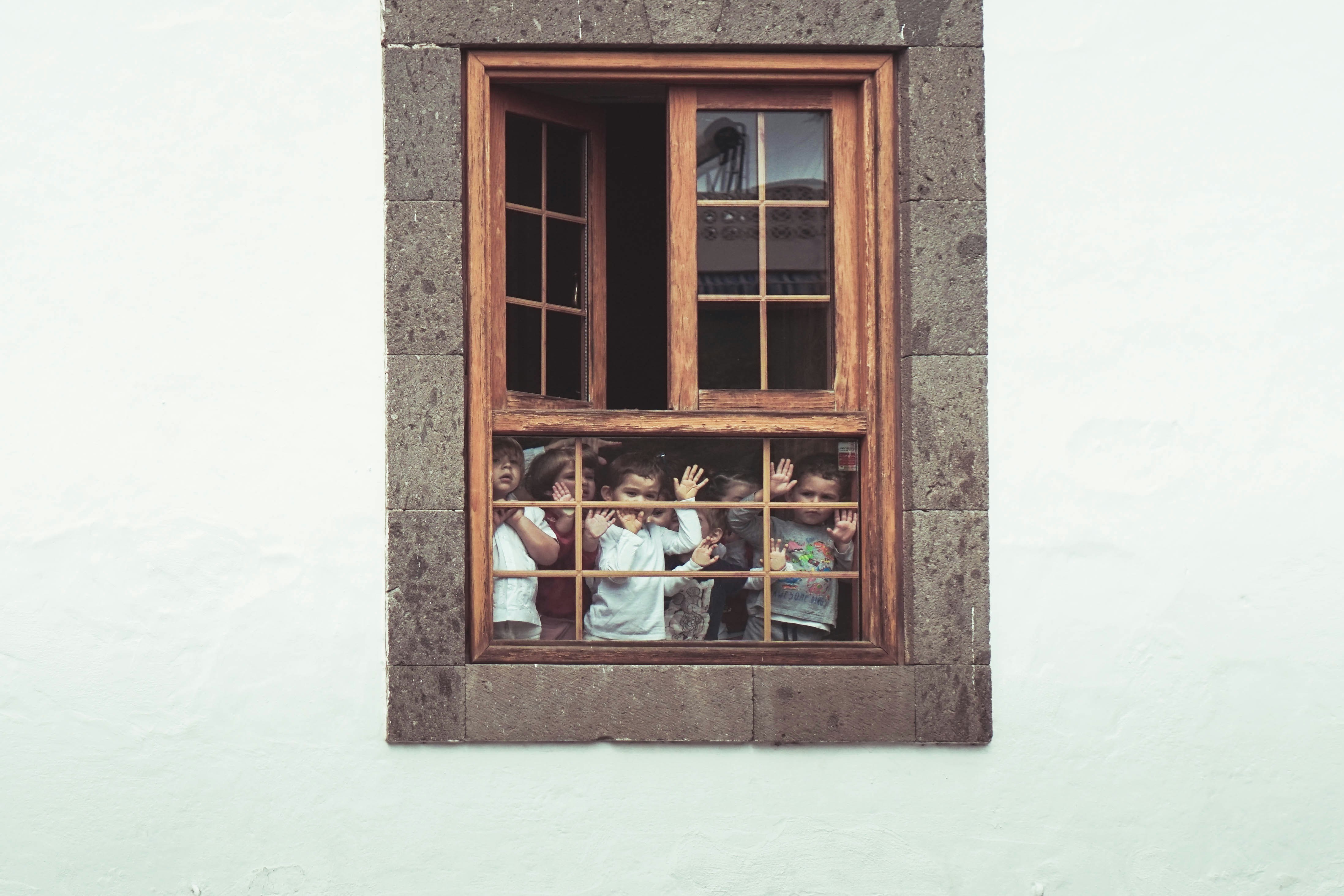 Kids behind the window of building photo – Free Grey Image on Unsplash