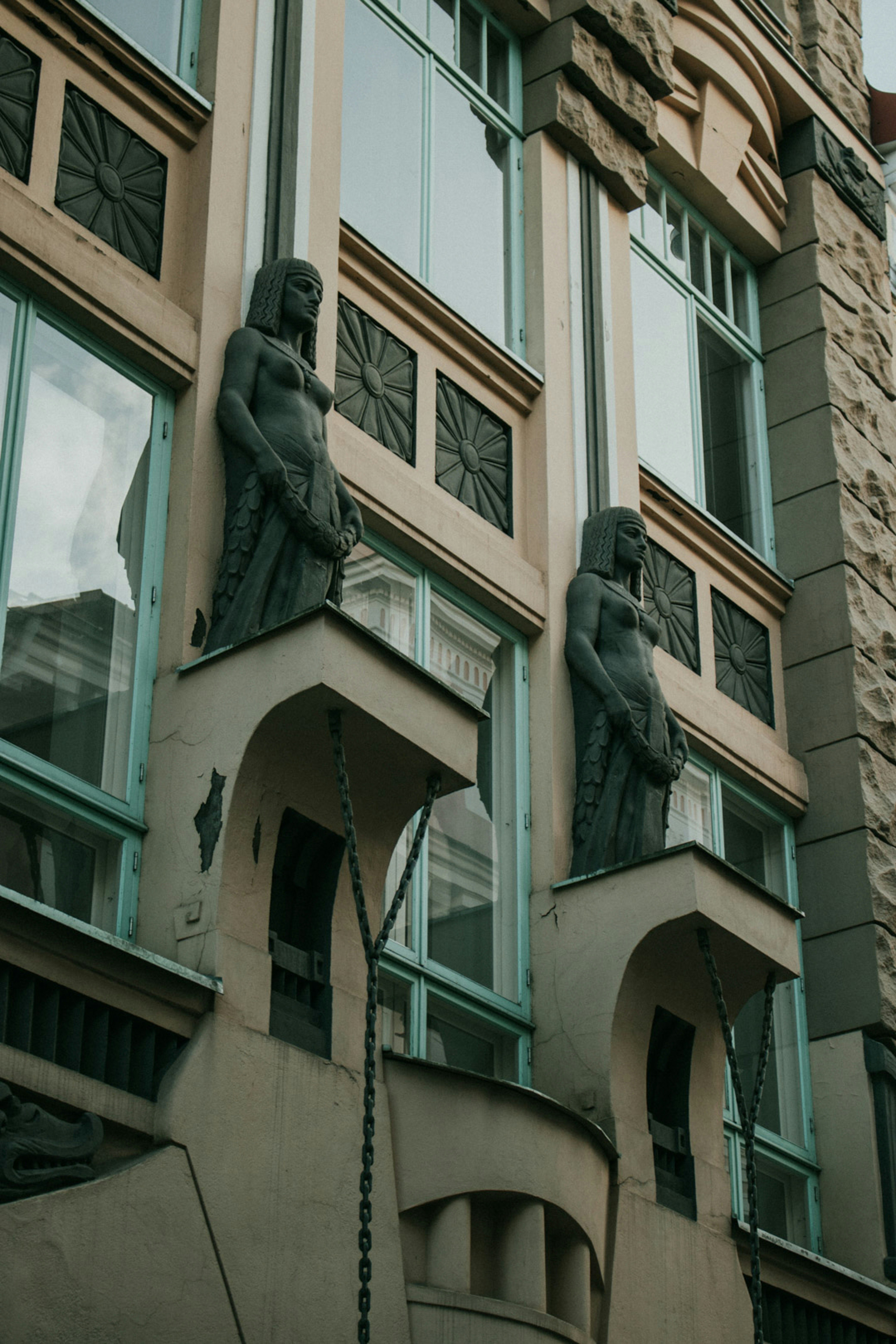 Twin Guardian Nymphs Adorn a Verdant Art Deco Façade