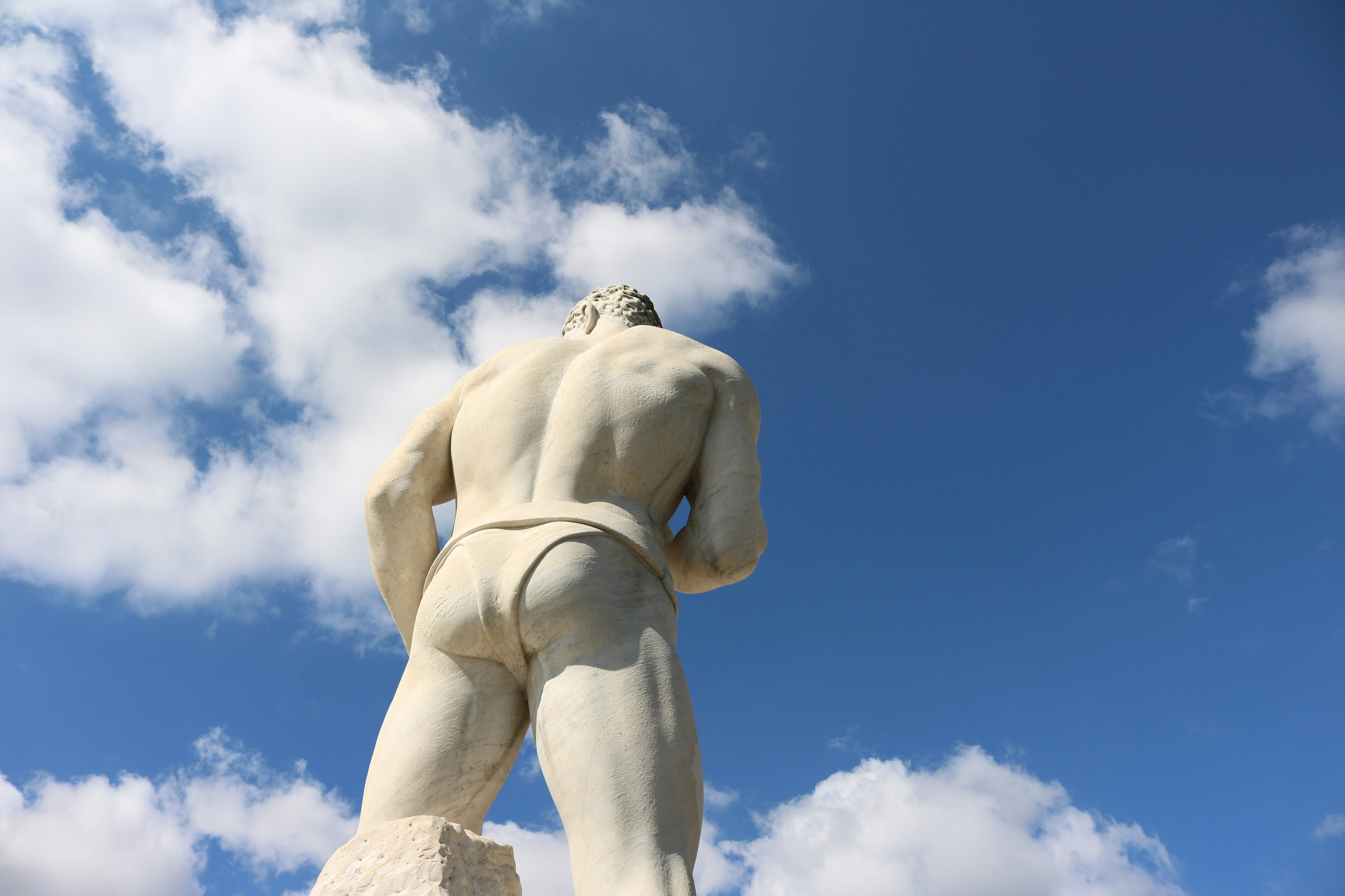 Titan on the Pedestal: Marble Muscles Under a Sapphire Sky