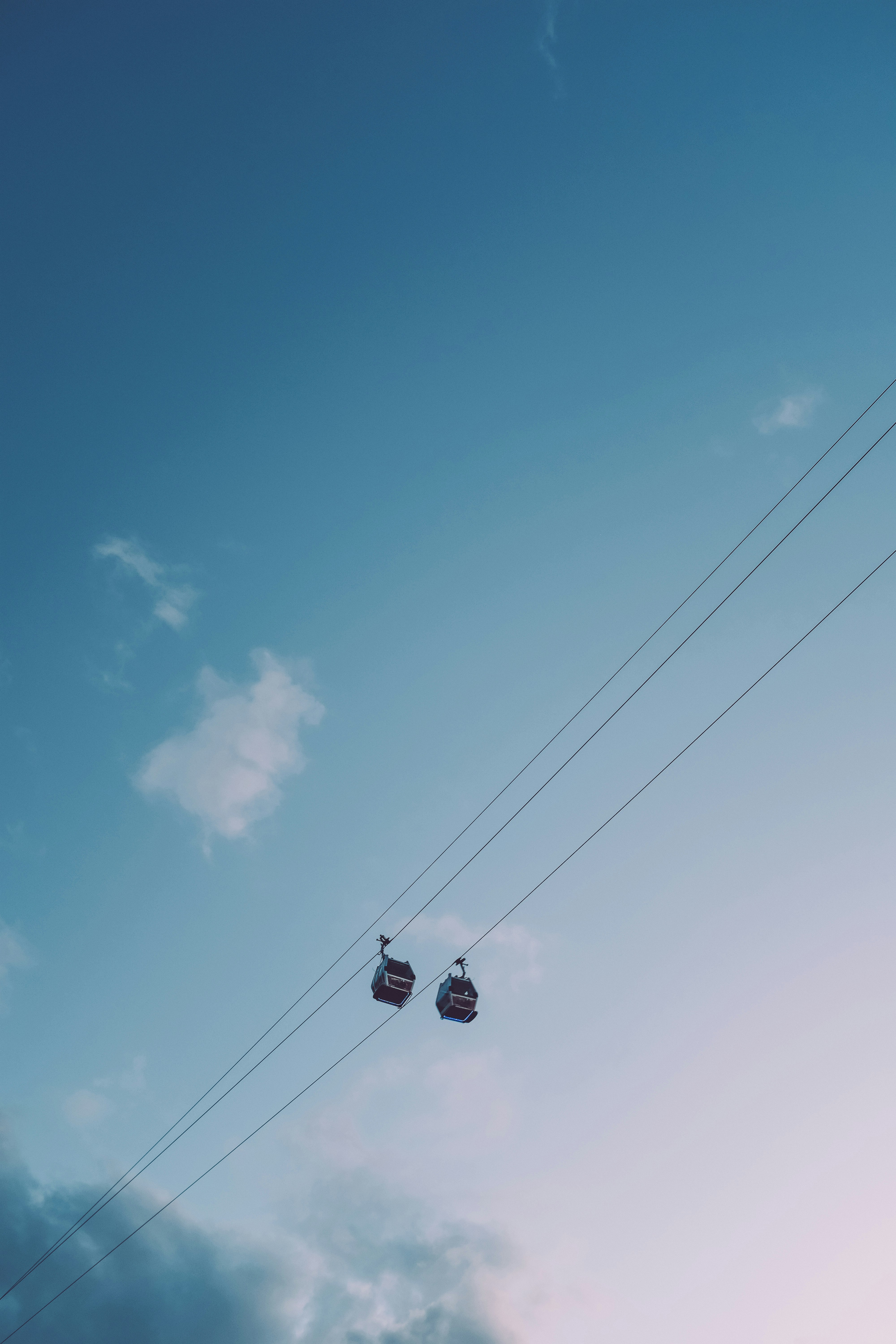 The cable car in Tbilisi. | a couple of gondolas hanging from a wire in the sky