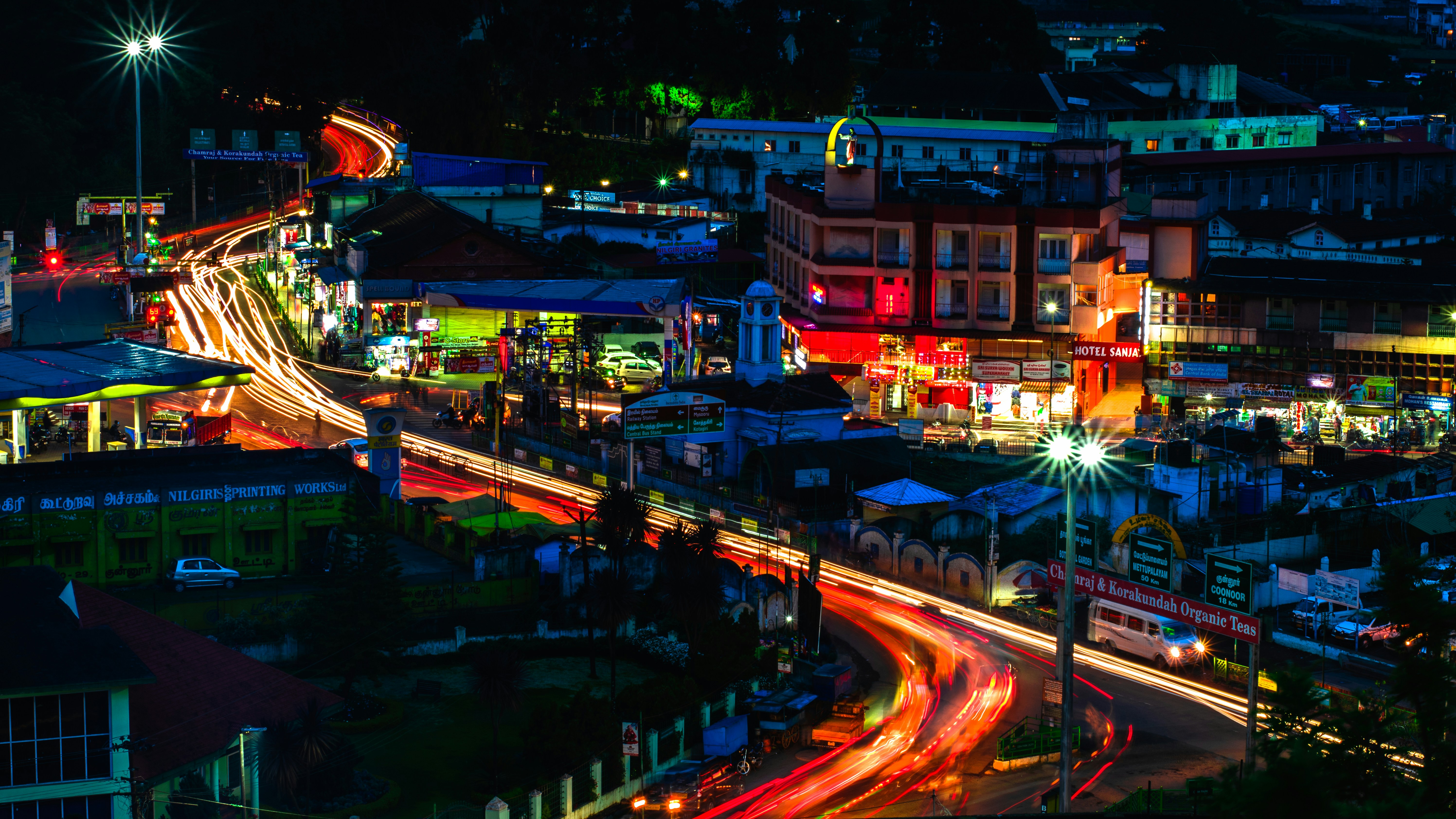 Nighttime cityscape showcasing vibrant traffic trails and illuminated storefronts, capturing the lively essence of urban life.
