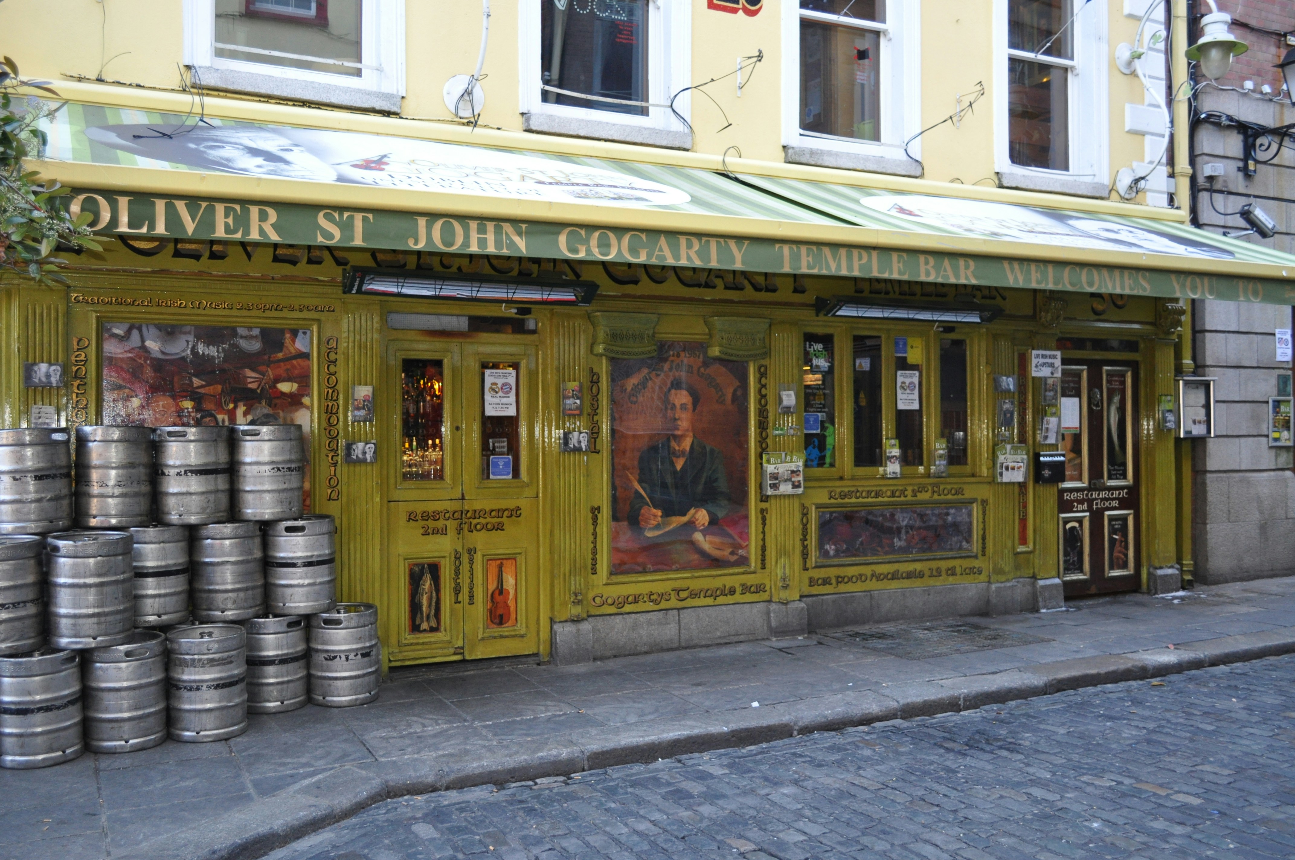 Vibrant pub exterior adorned with murals and stacked kegs, showcasing the lively spirit of Dublin's Temple Bar district.