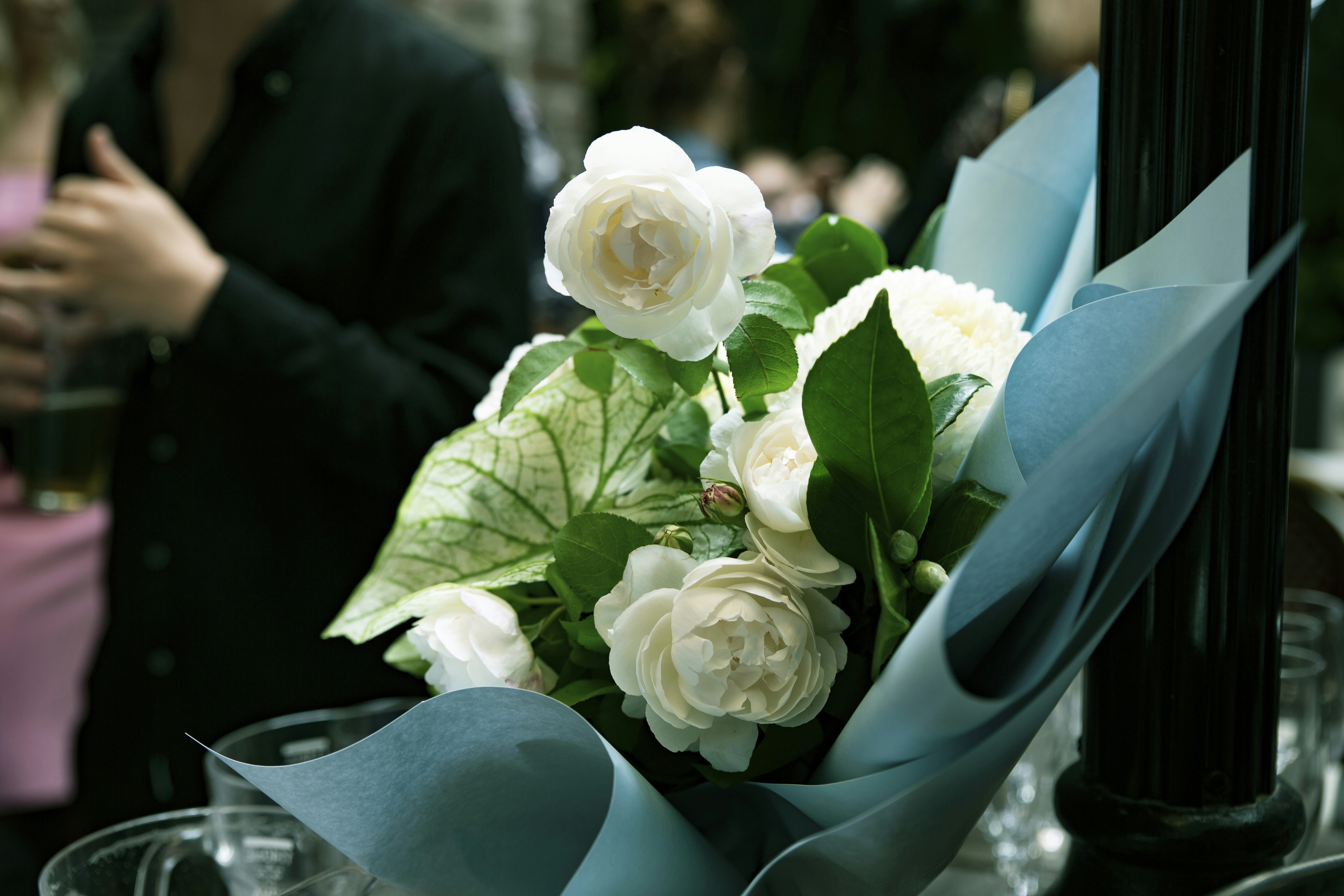 White Rose Bouquet with Teal Wrapping at a Formal Event