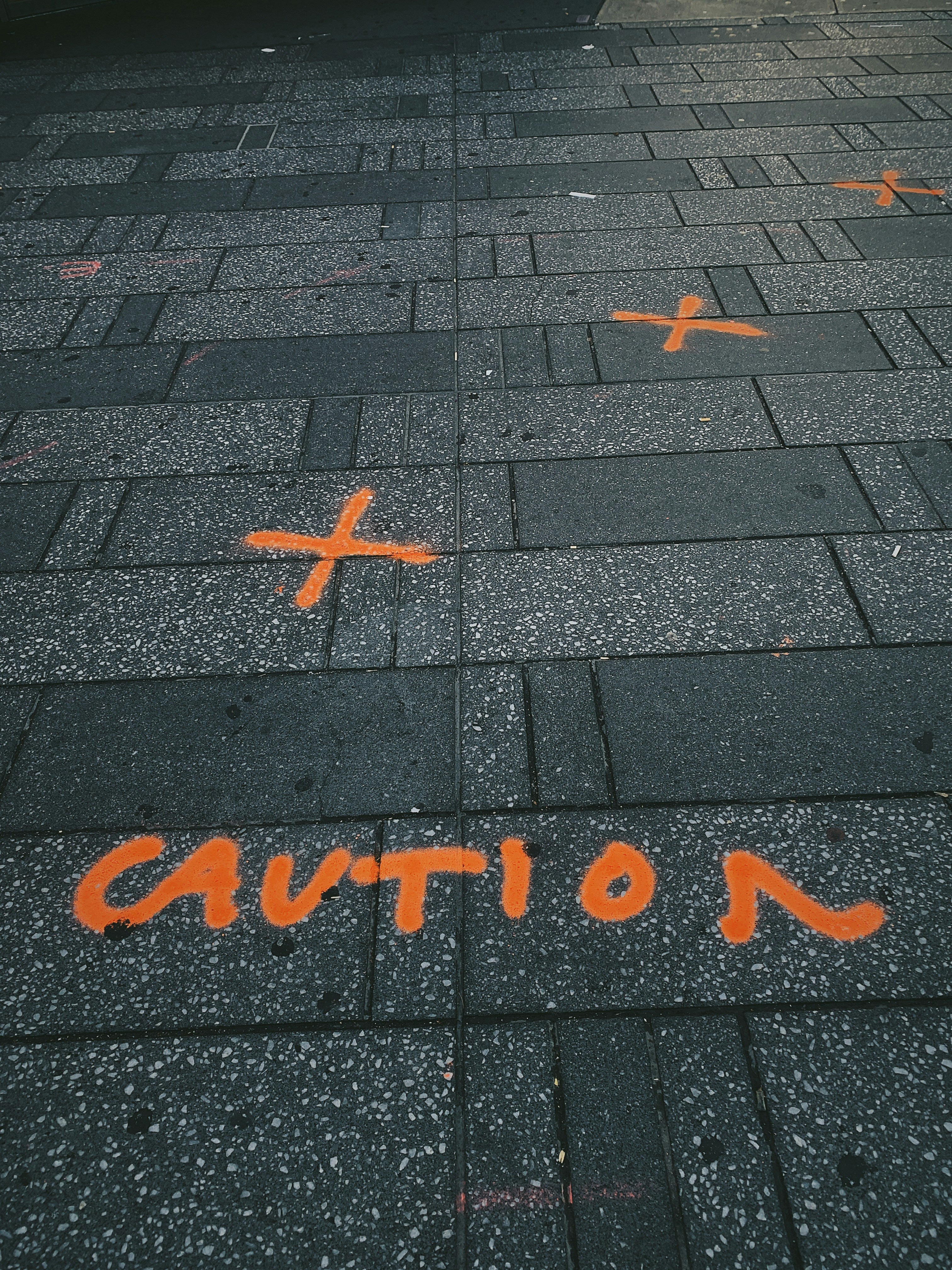 Orange Warning Marks on a Wet Street: Caution in Chalked Steps
