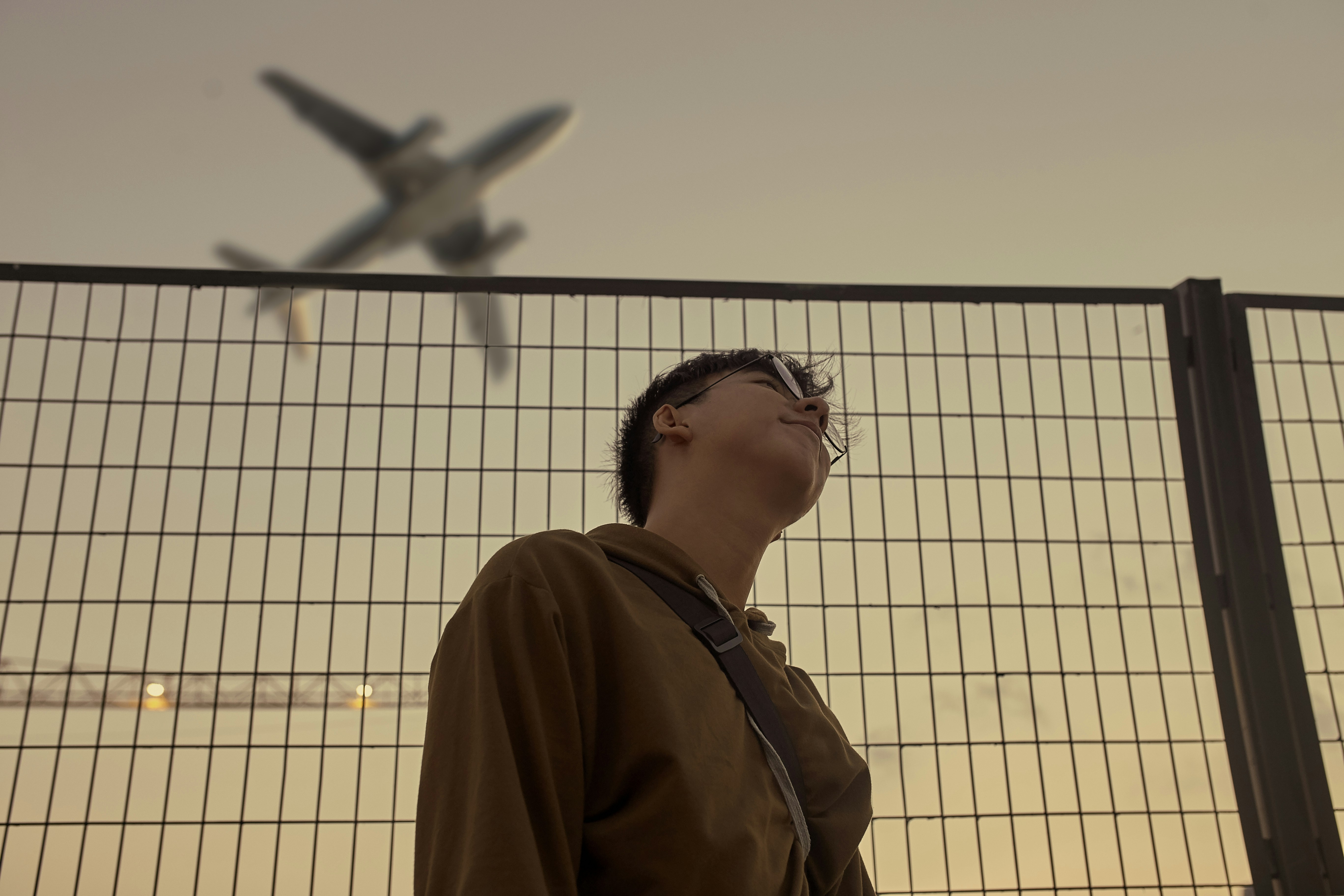 Chin Up, Skyward Gaze: Portrait Beneath a Distant Jet