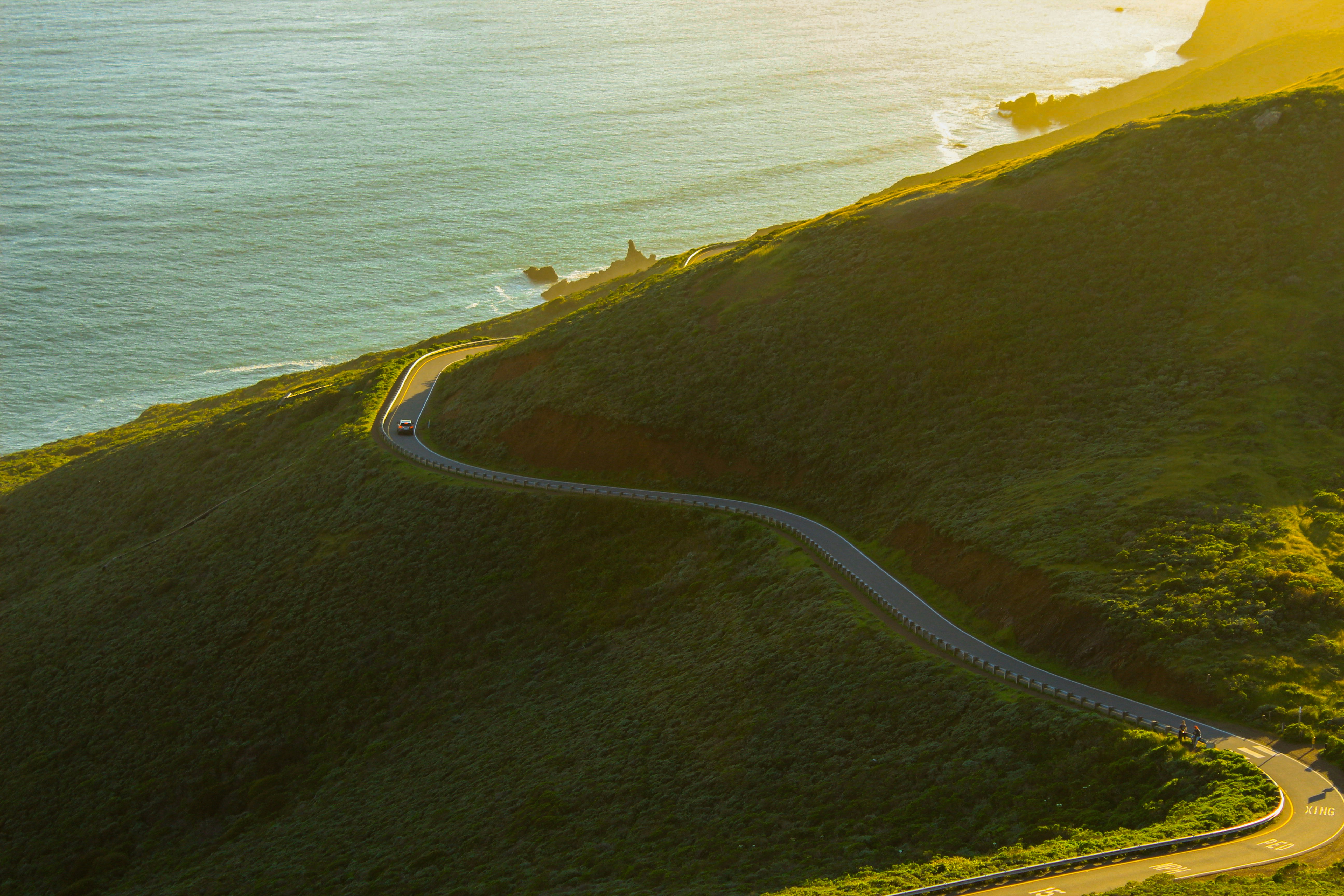 Golden Hour Switchback: A Lone Car on the Coastal Spiral