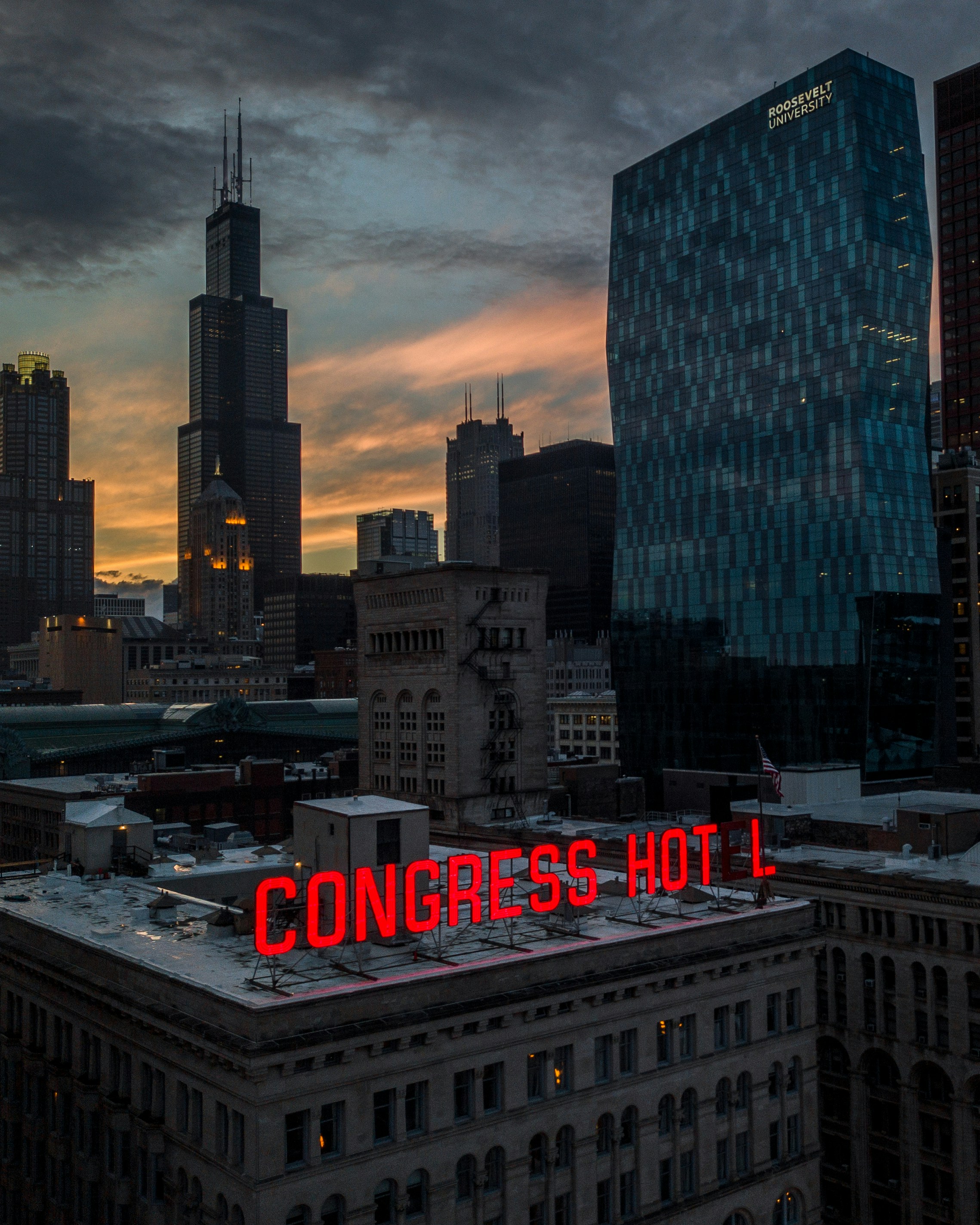 A large neon sign on top of a tall building photo – Free Building Image ...