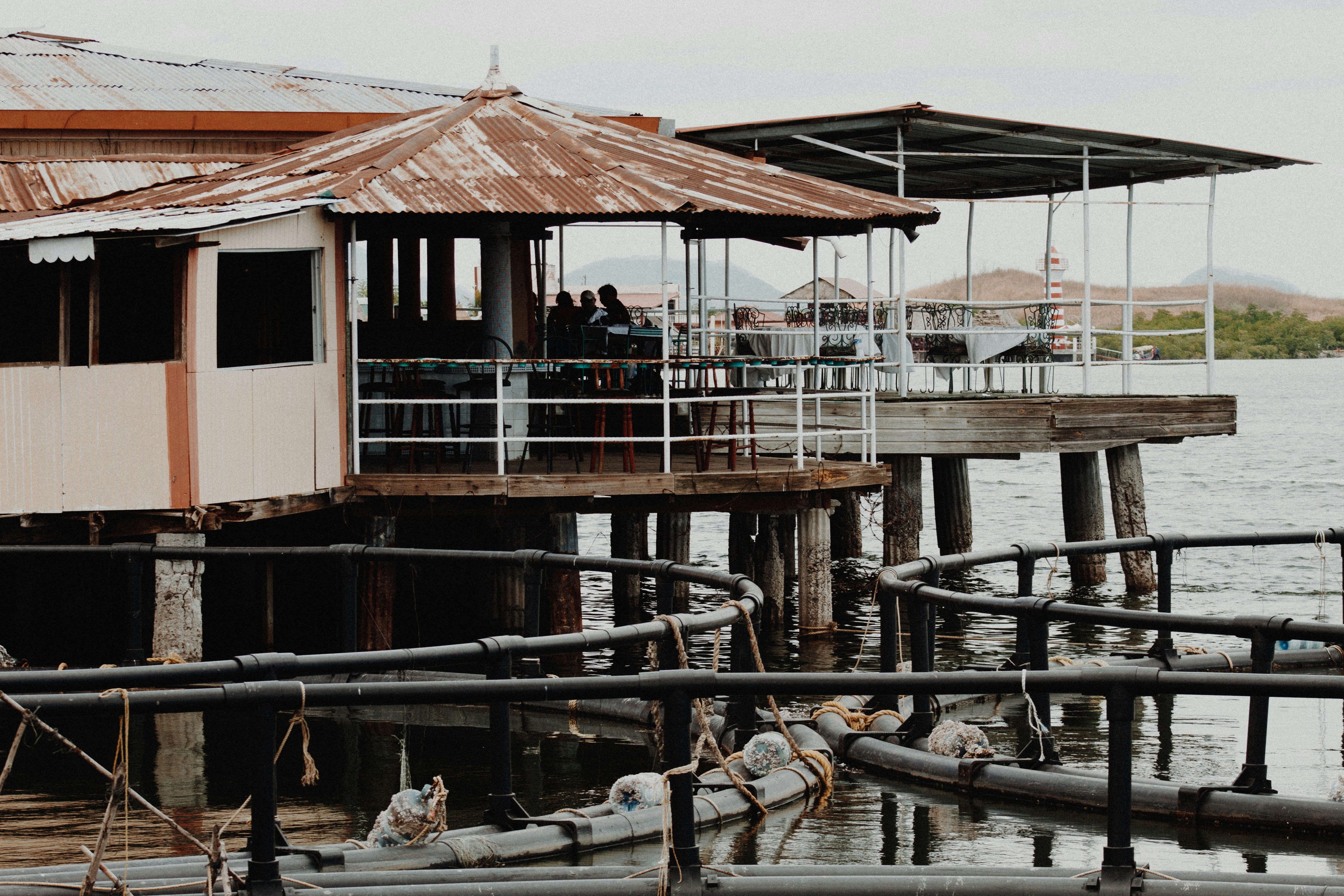 Stilted Wharfside Café: Rusted Roofs and Quiet Lagoon Light