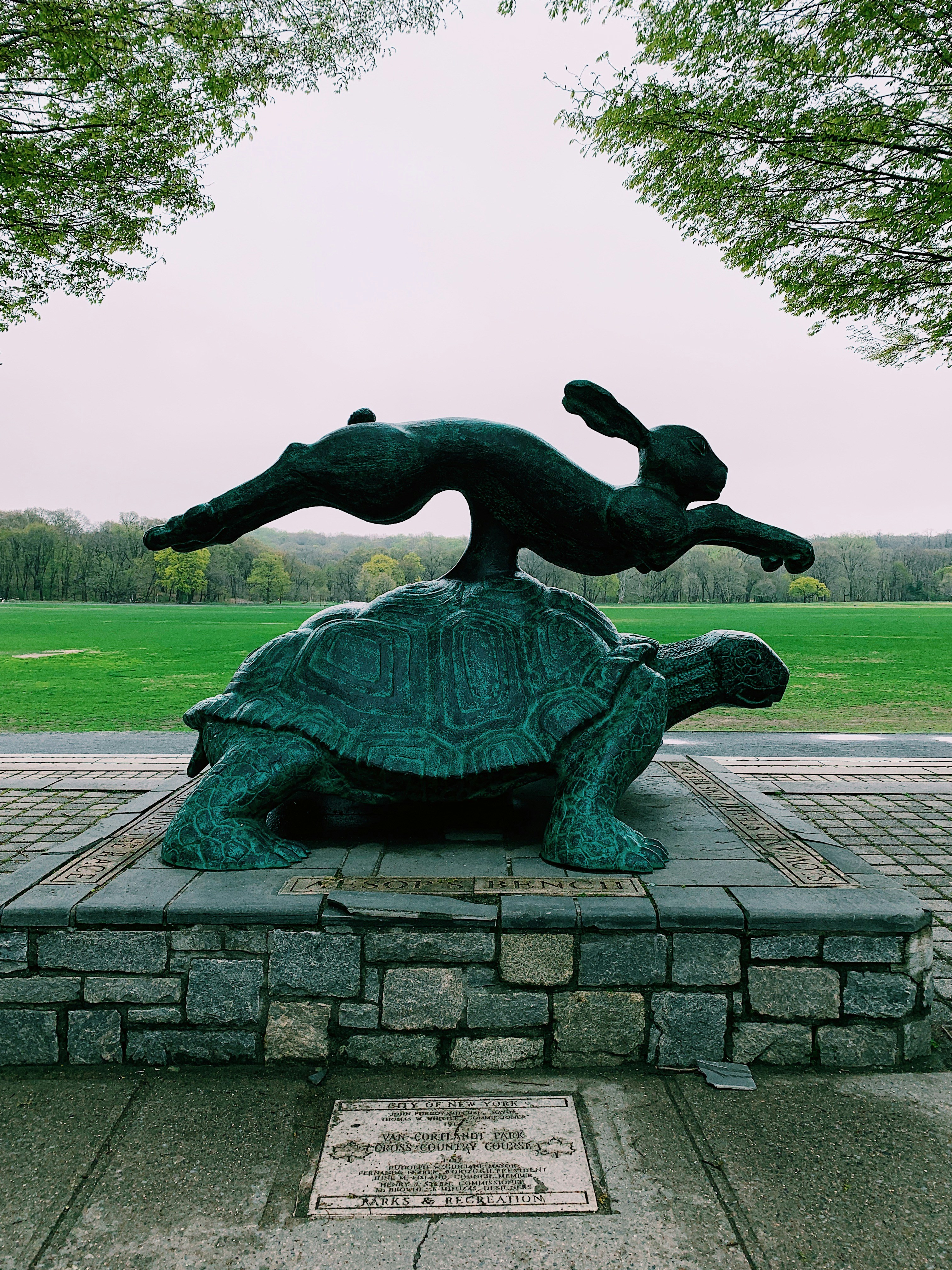 Bronze Acrobat on a Park Turtle: Balance Under a Green Canopy