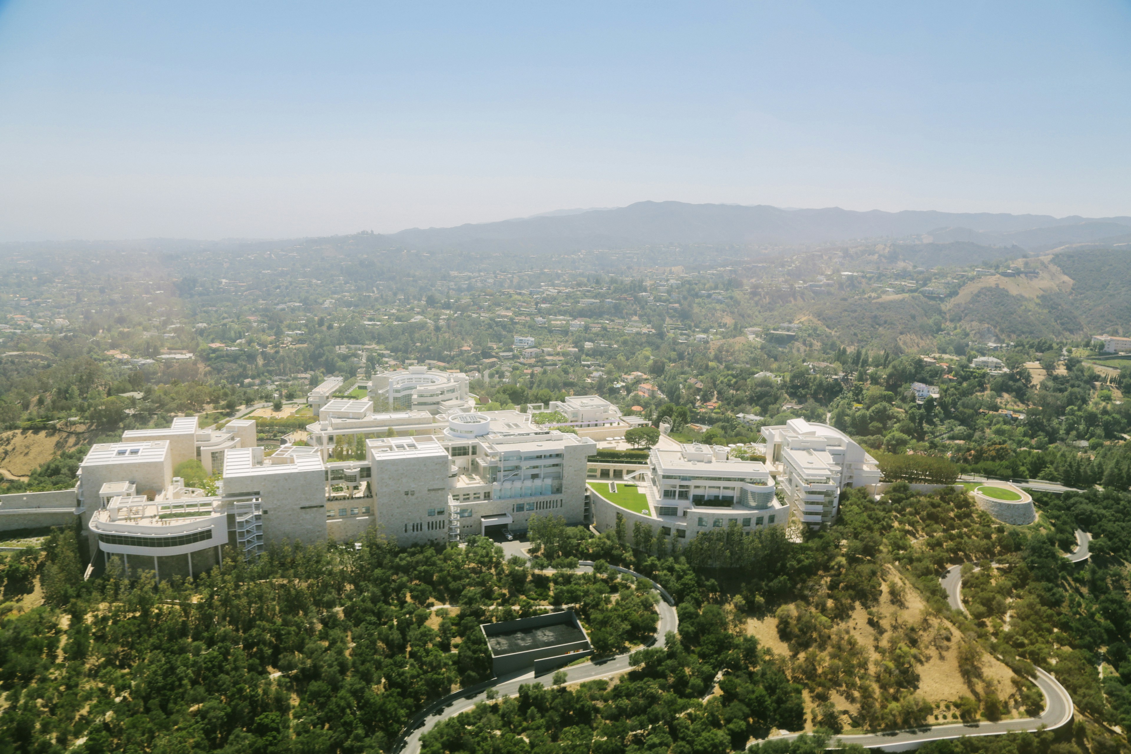 Aerial view of the sprawling Getty Museum surrounded by lush greenery and distant hills.