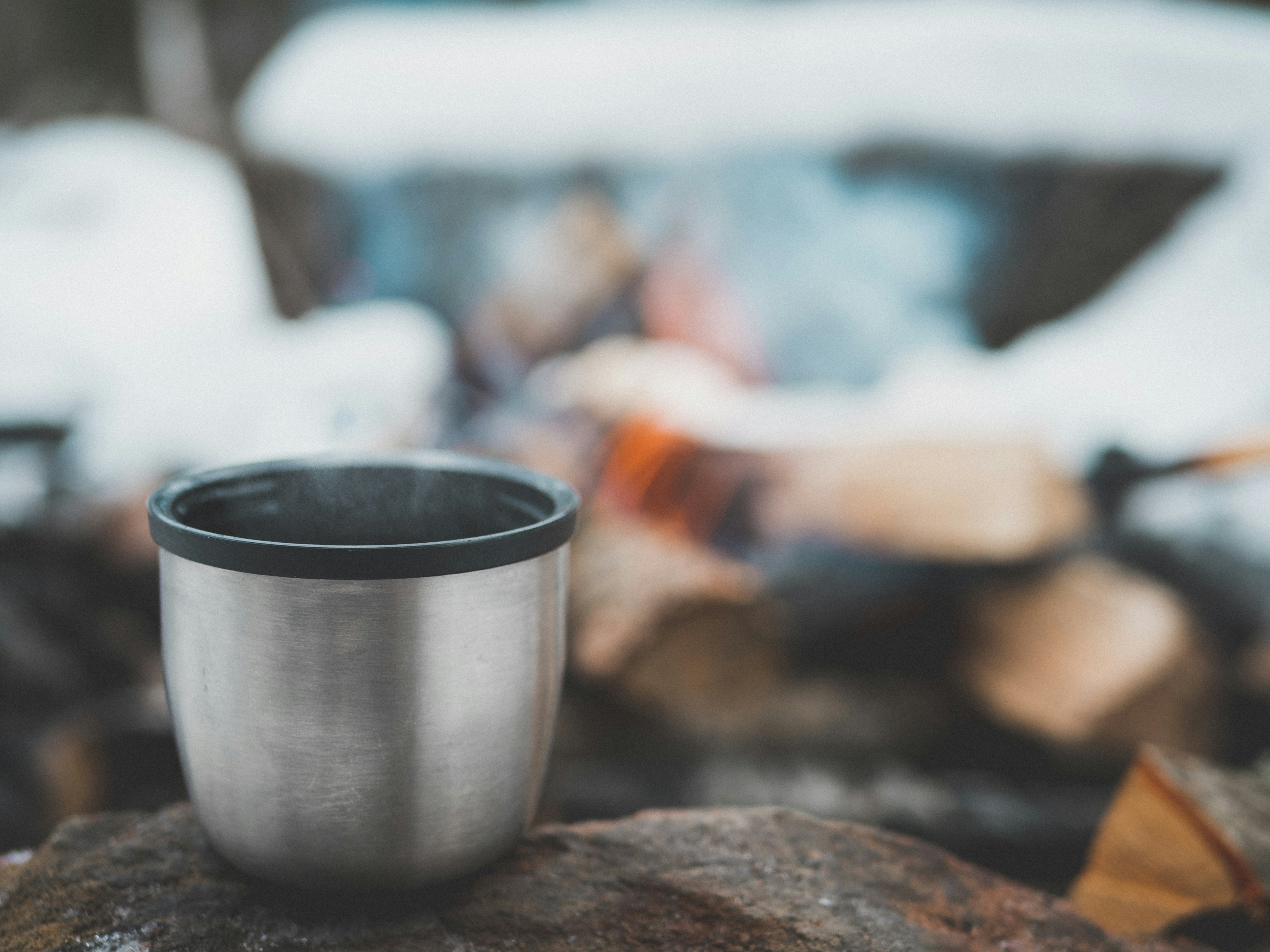 Steel mug on a rocky riverside fireside break