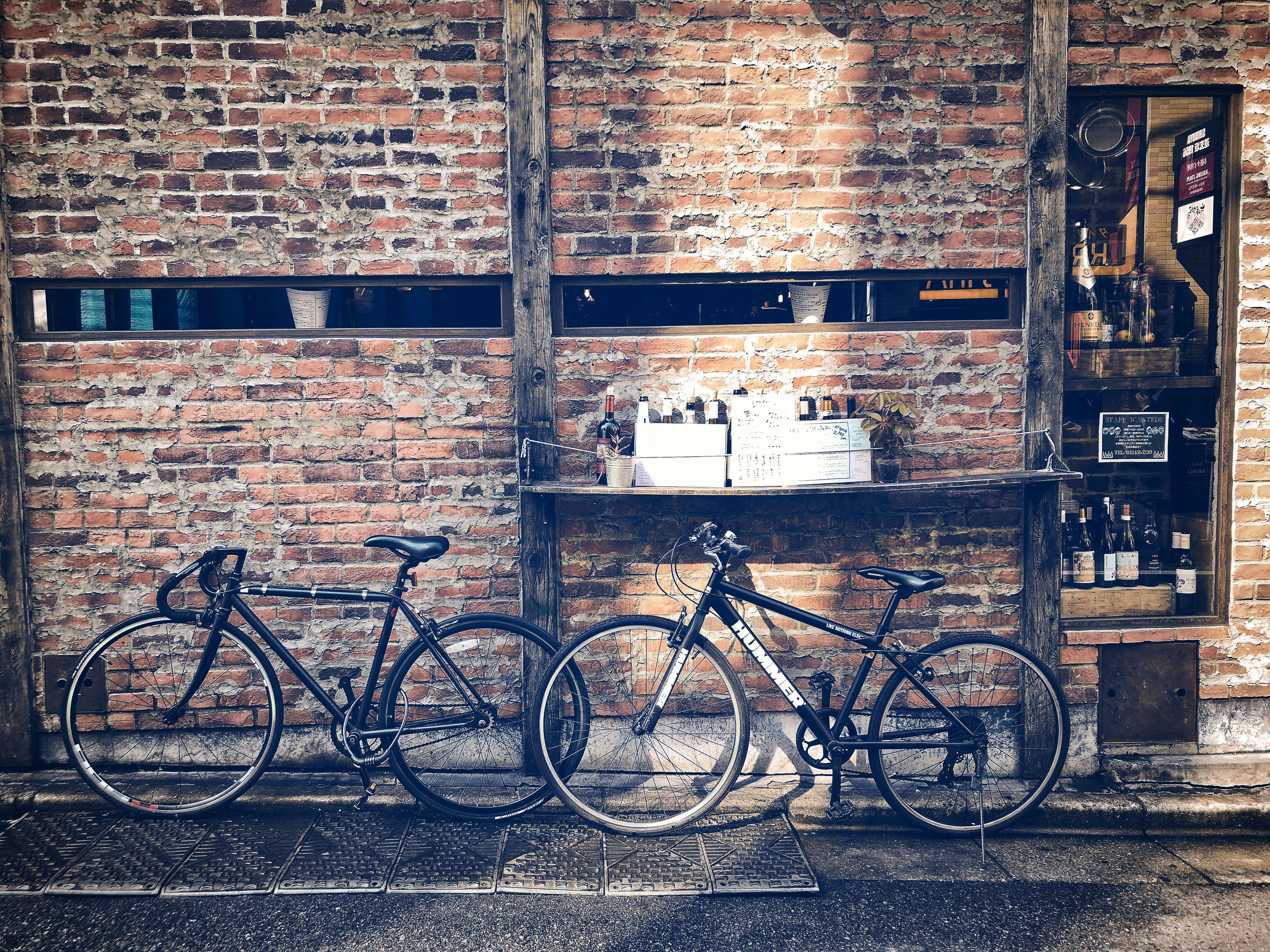 two black bikes in front red brick wall