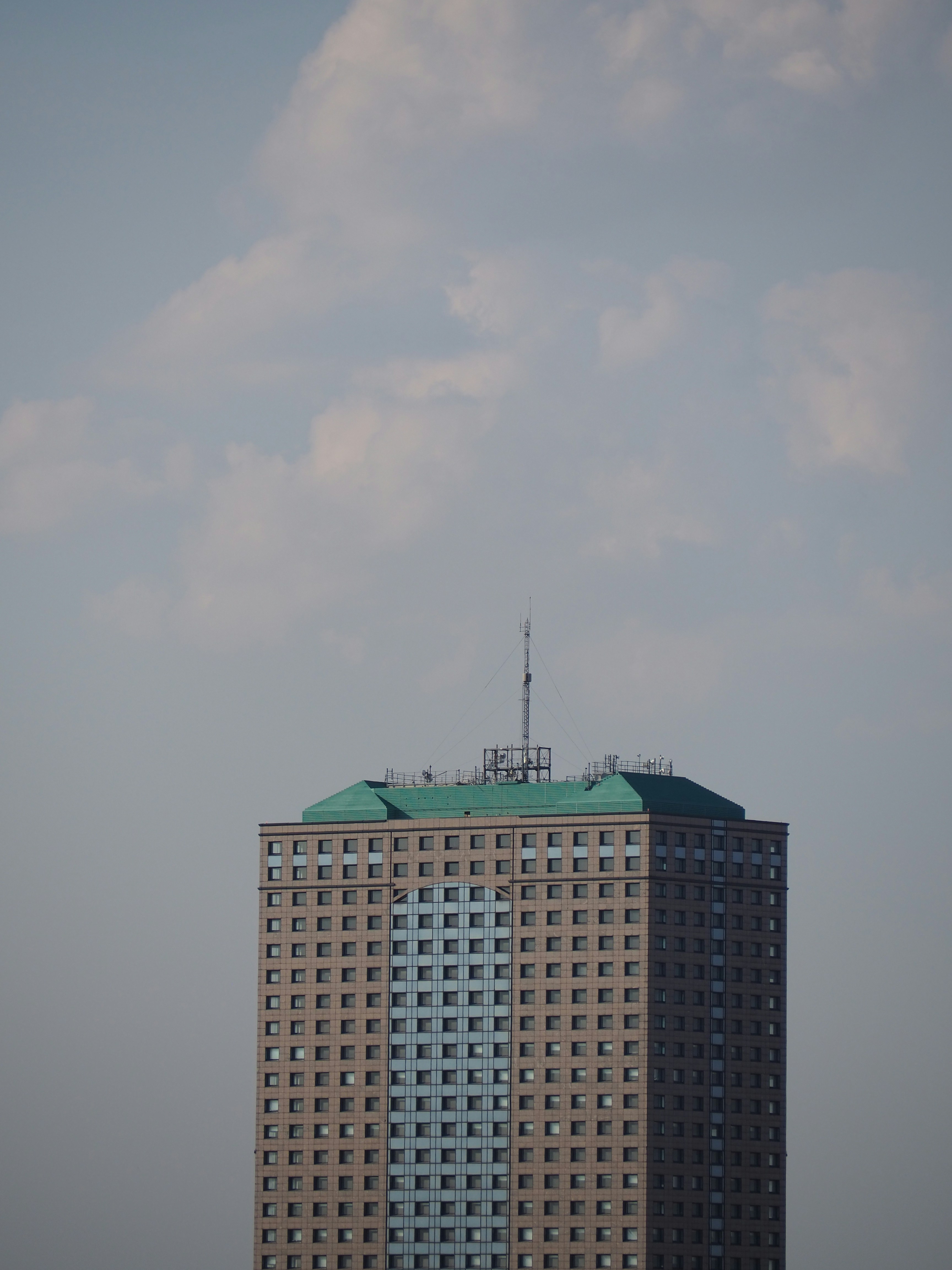 Emerald-Capped Skyscraper Against a Calm Blue Sky