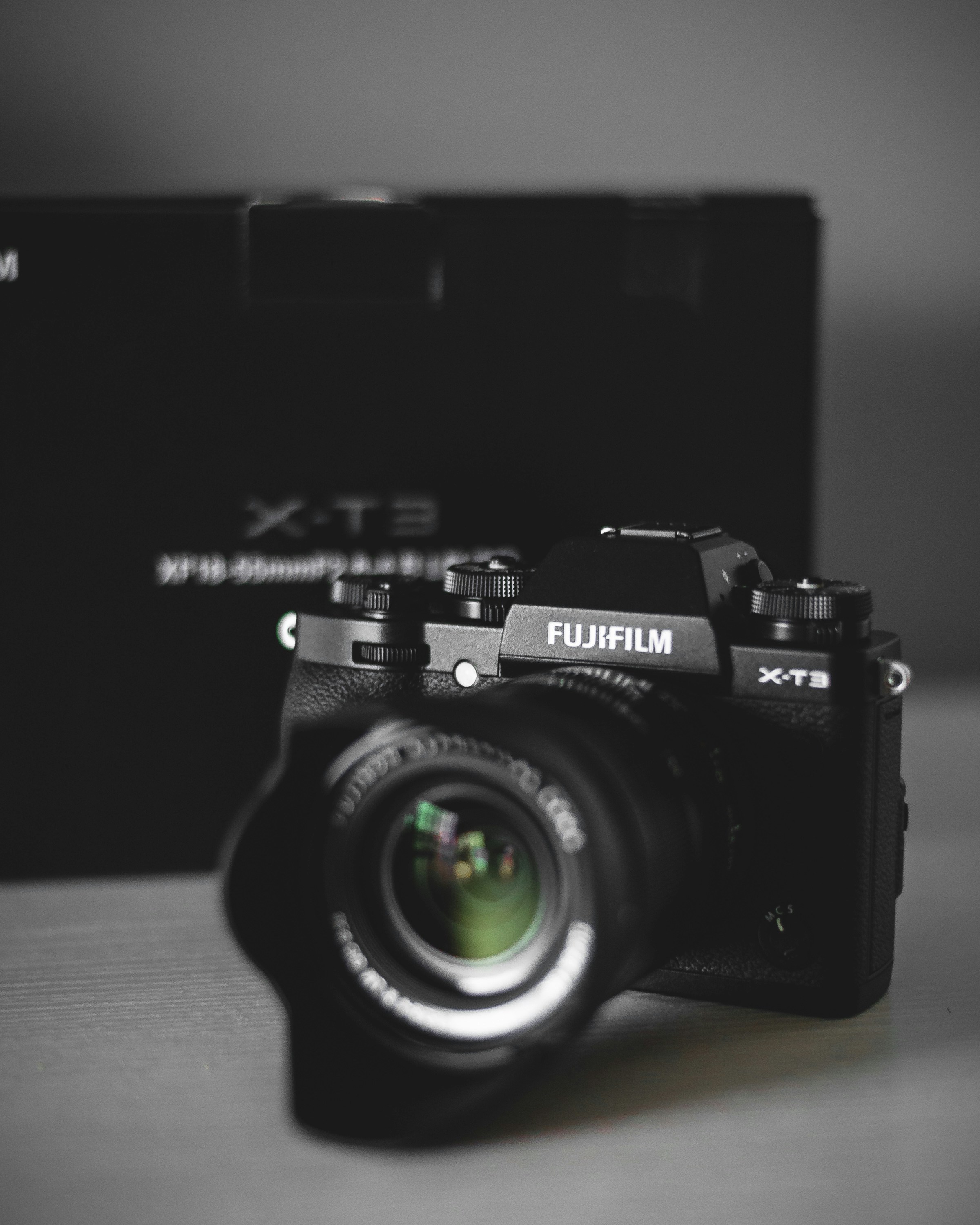 Fujifilm X-T3 camera prominently displayed with its lens, set against a sleek black background. The design emphasizes the camera's professional appeal.