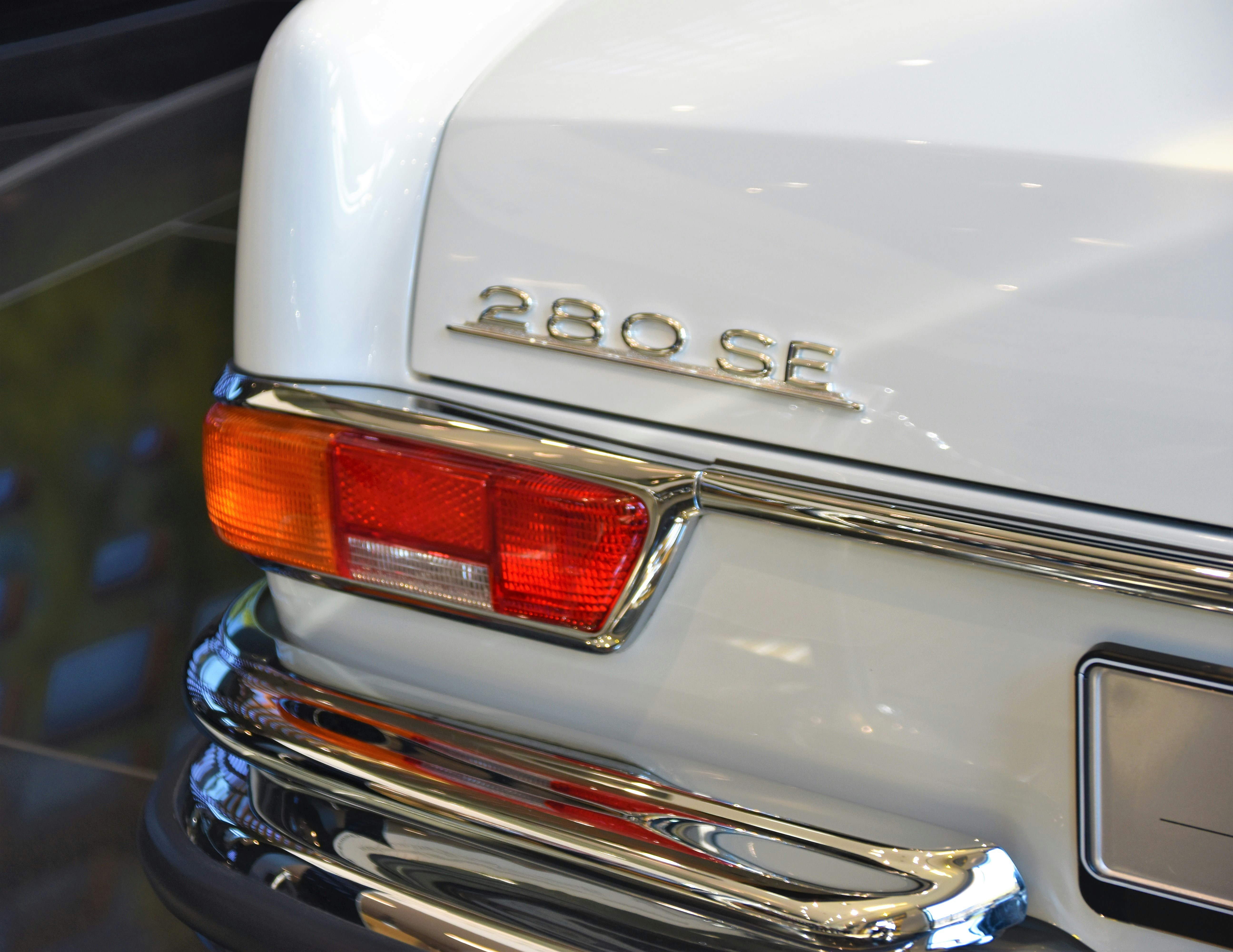 Close-up of the rear badge and taillight of a classic 280 SE car, showcasing its vintage design and chrome details.