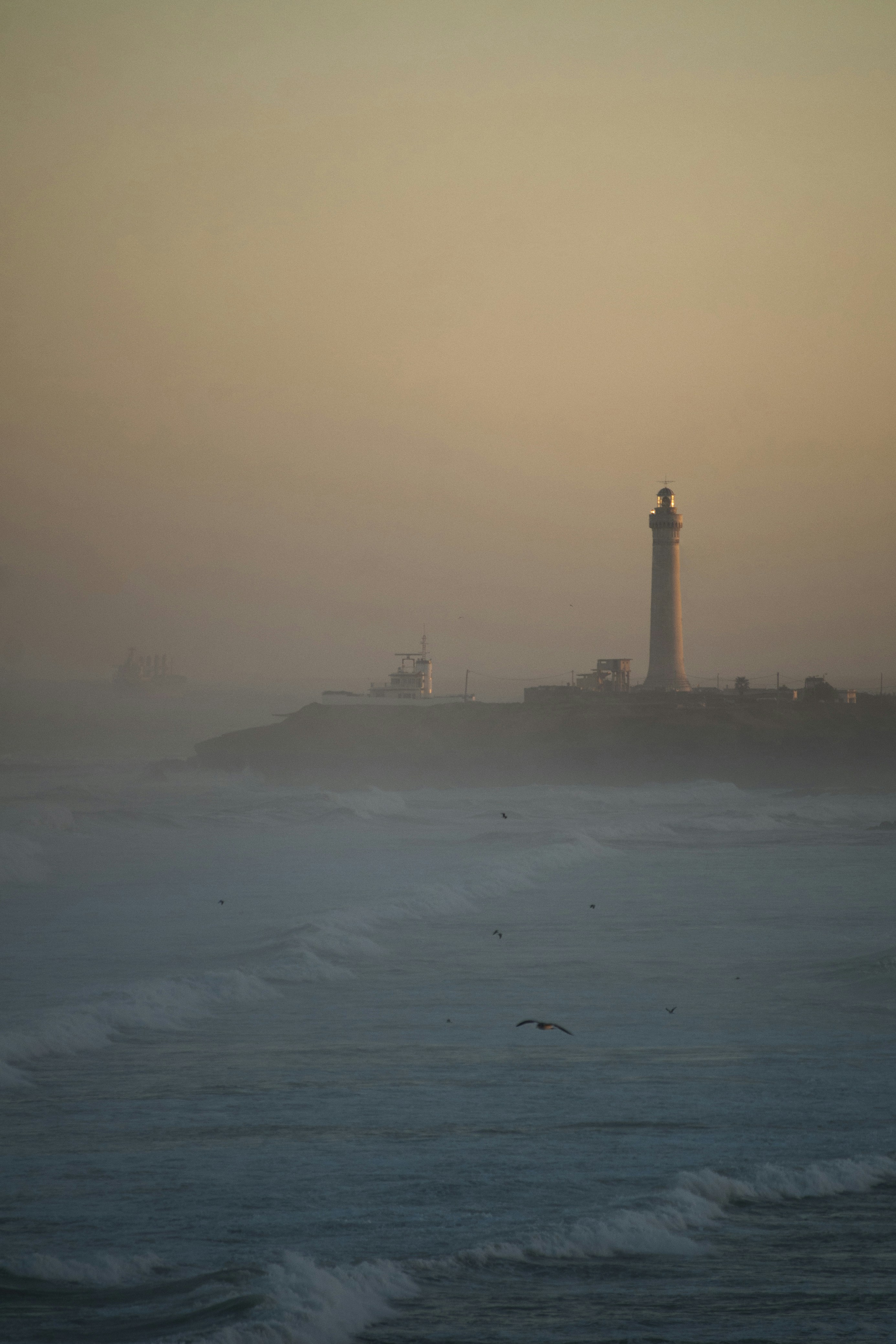 First Light on the Mist-Wrapped Cape Lighthouse