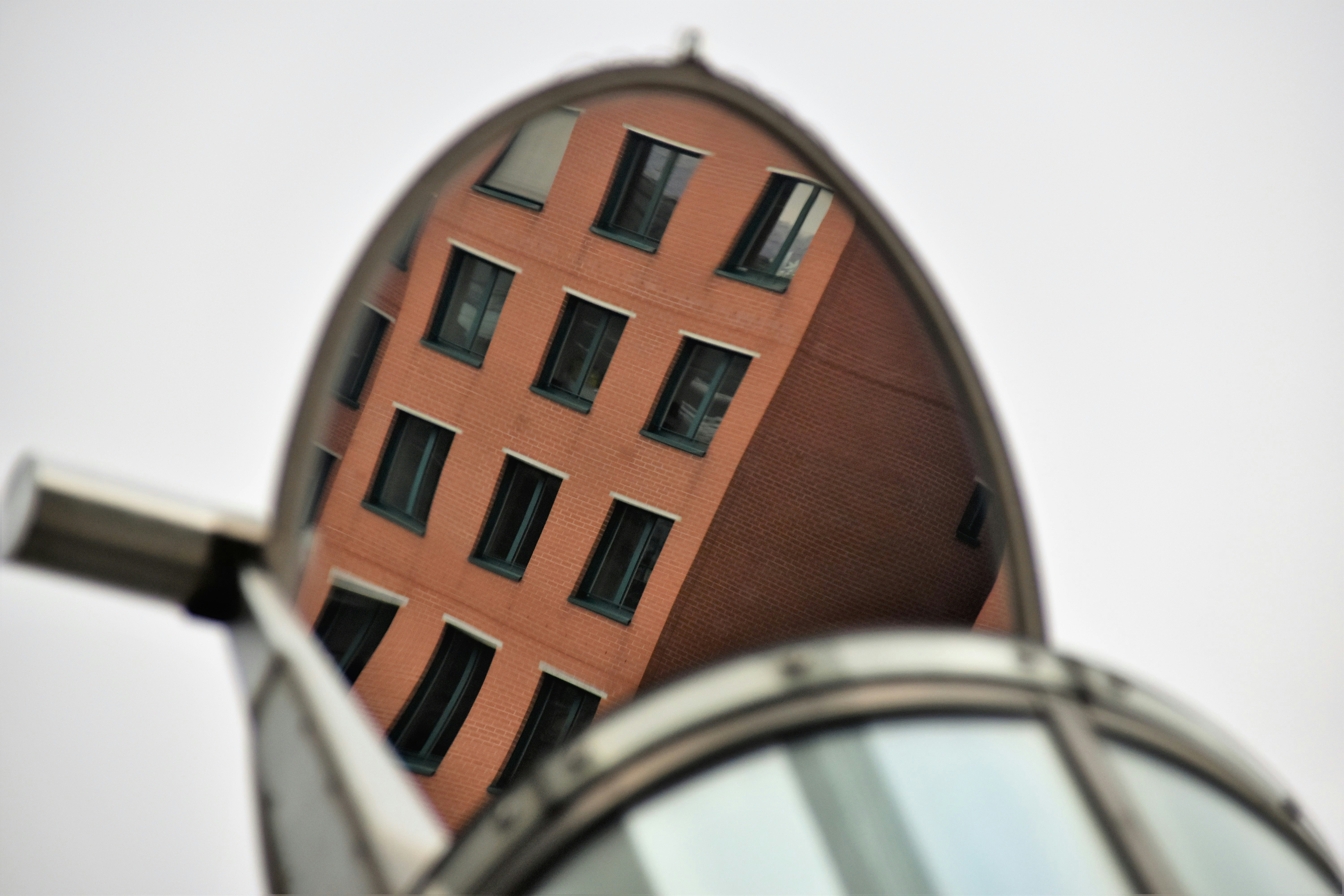Oval Mirror, Brick Facade: A Quiet Angle on Architecture